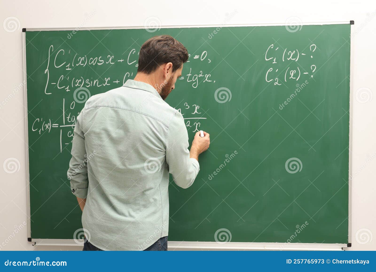 Mature Teacher Explaining Mathematics at Chalkboard in Classroom Stock ...