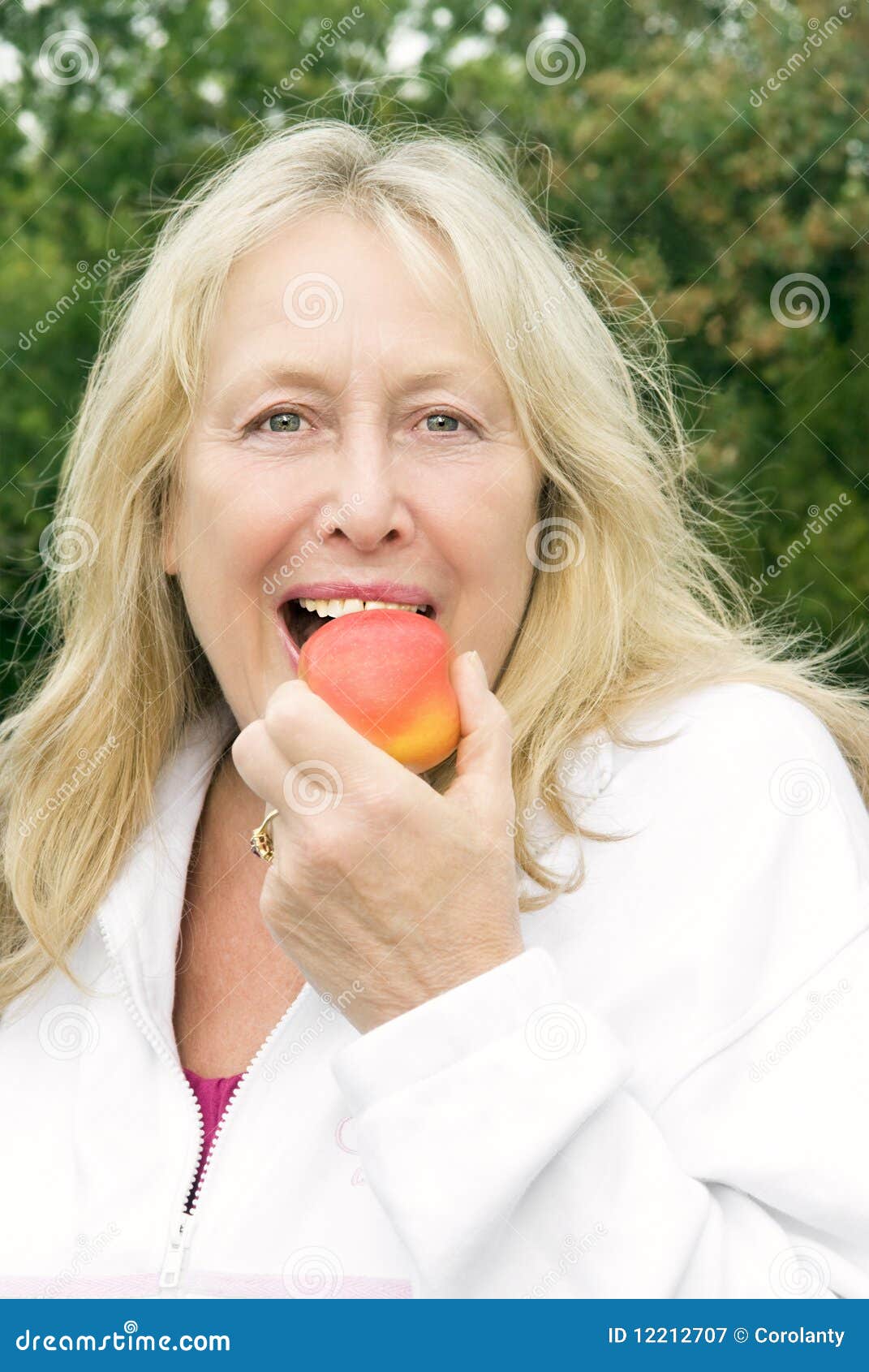 Mature woman biting apple stock image. Image of sixties - 12212707
