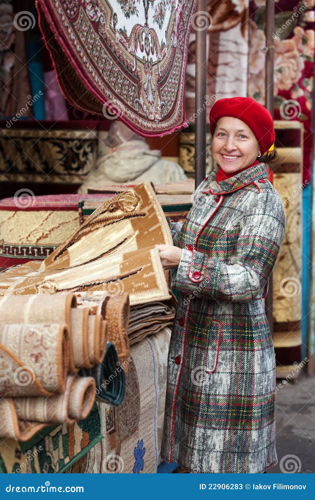 Mature woman chooses rug stock image. Image of cheerful - 22906283