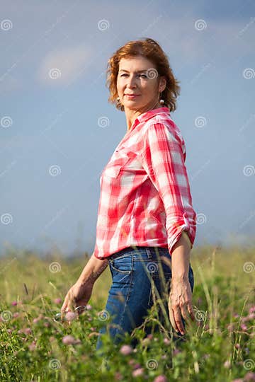 Mature Woman Dressed Red Shirt Standing In Deep And Green Grass On A