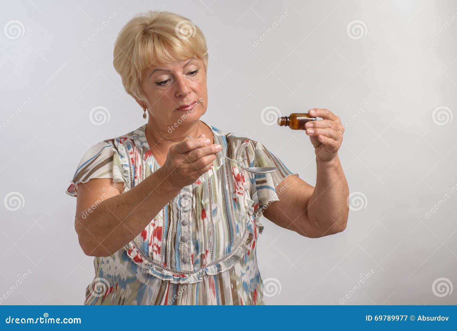 Mature Woman Dripping Medicine into a Spoon Stock Image - Image of ...