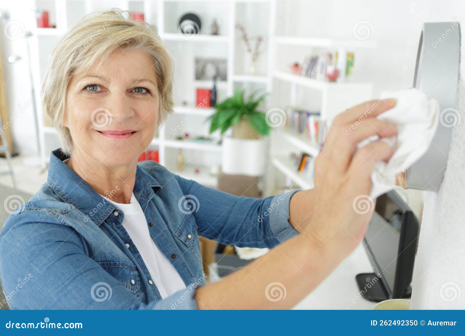 Mature woman dusting home stock photo. Image of cloth - 262492350