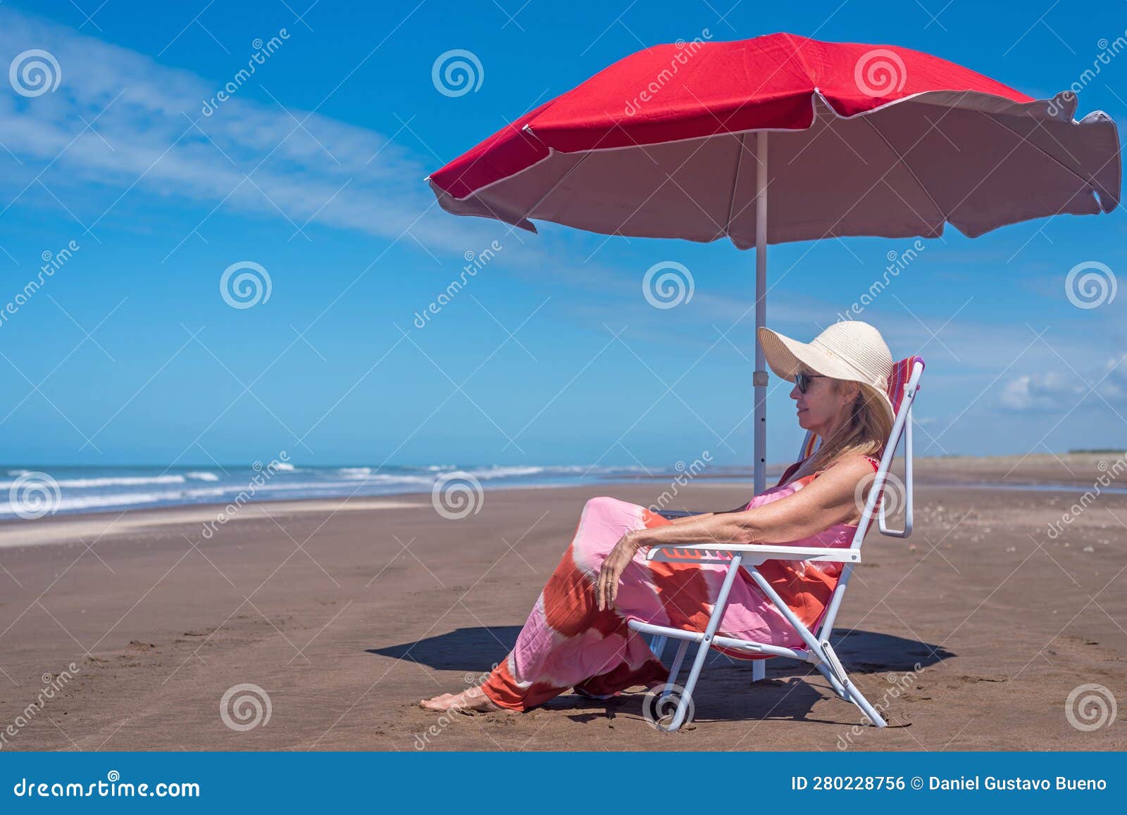 Mature Woman Enjoying The View While Relaxing Sitting On A Beach Chair