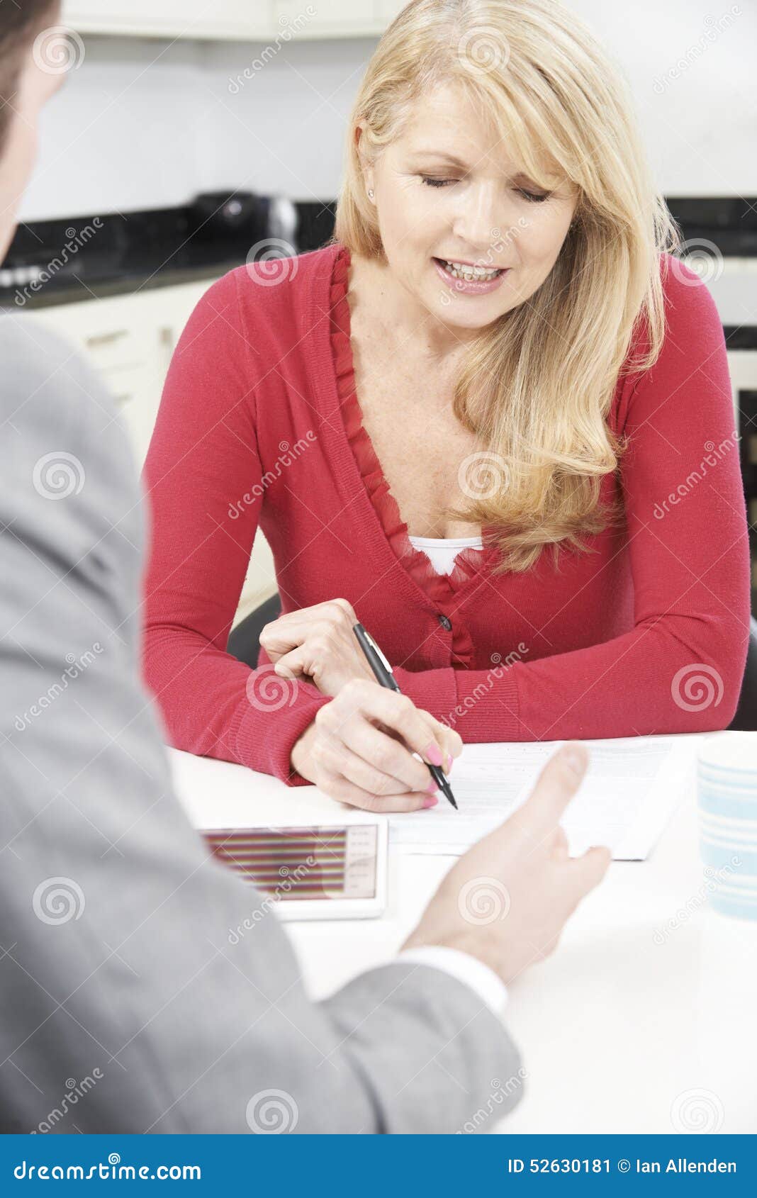 Mature Woman with Financial Advisor Signing Document at Home Stock ...