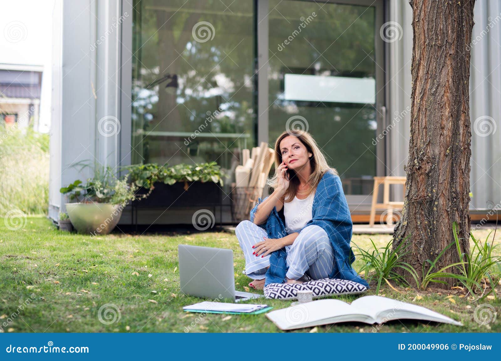 Mature Woman In Pajamas Working In Home Office Outdoors In Garden
