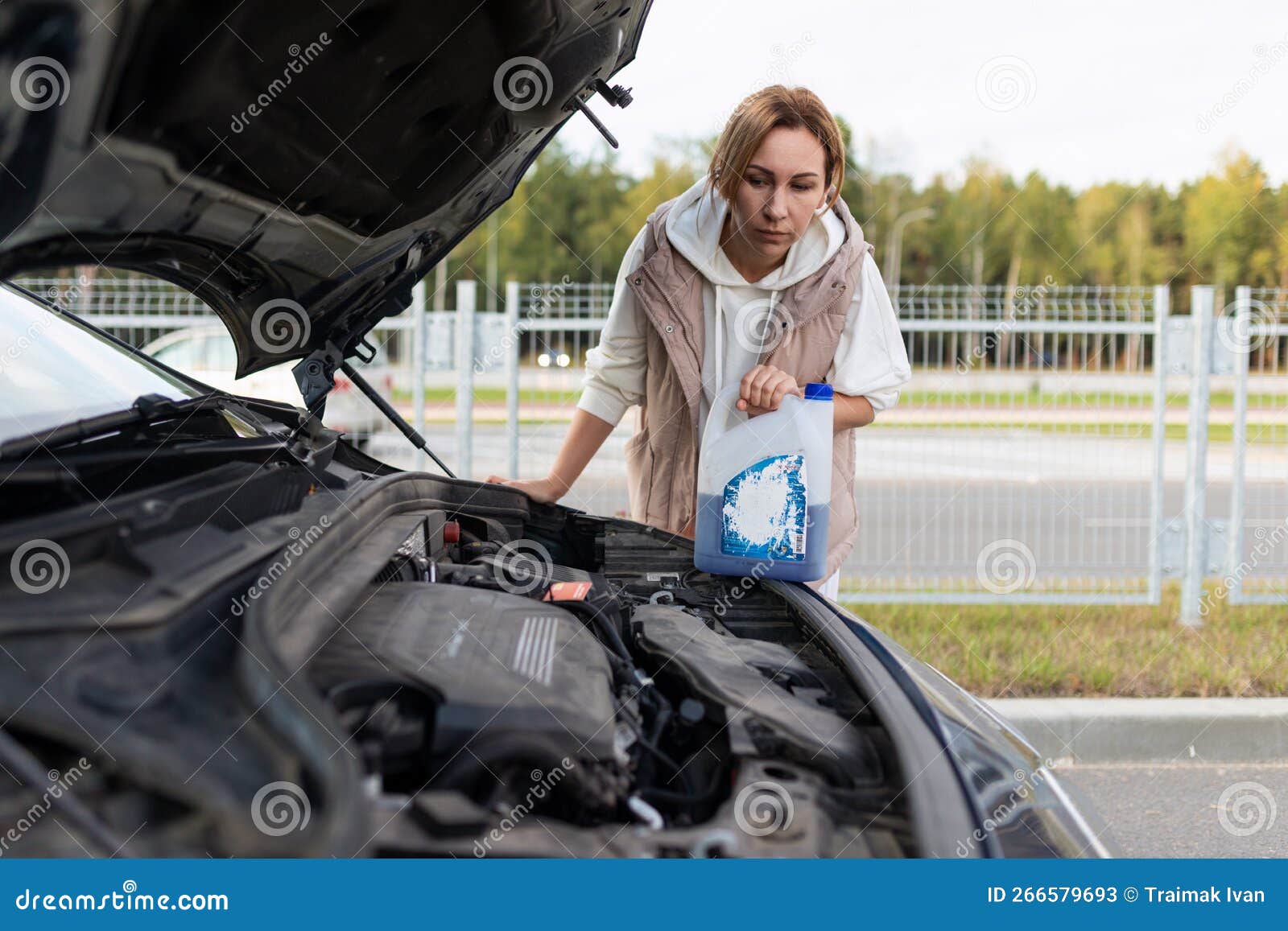 Mature Woman Pours Coolant into the Engine of a Broken Car Stock Image ...
