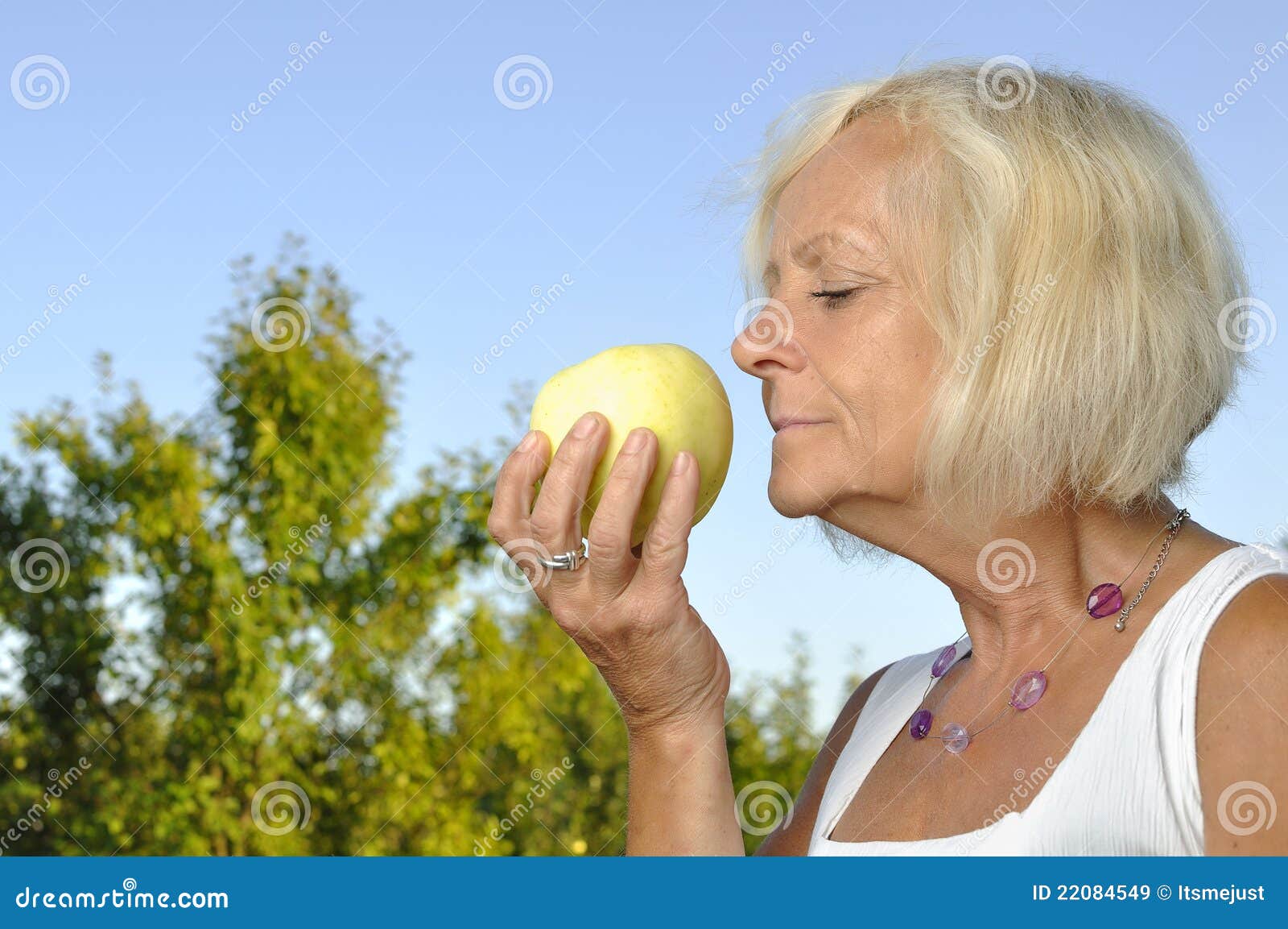Mature Woman Smelling Apple. Stock Image - Image of holds, outdoor ...