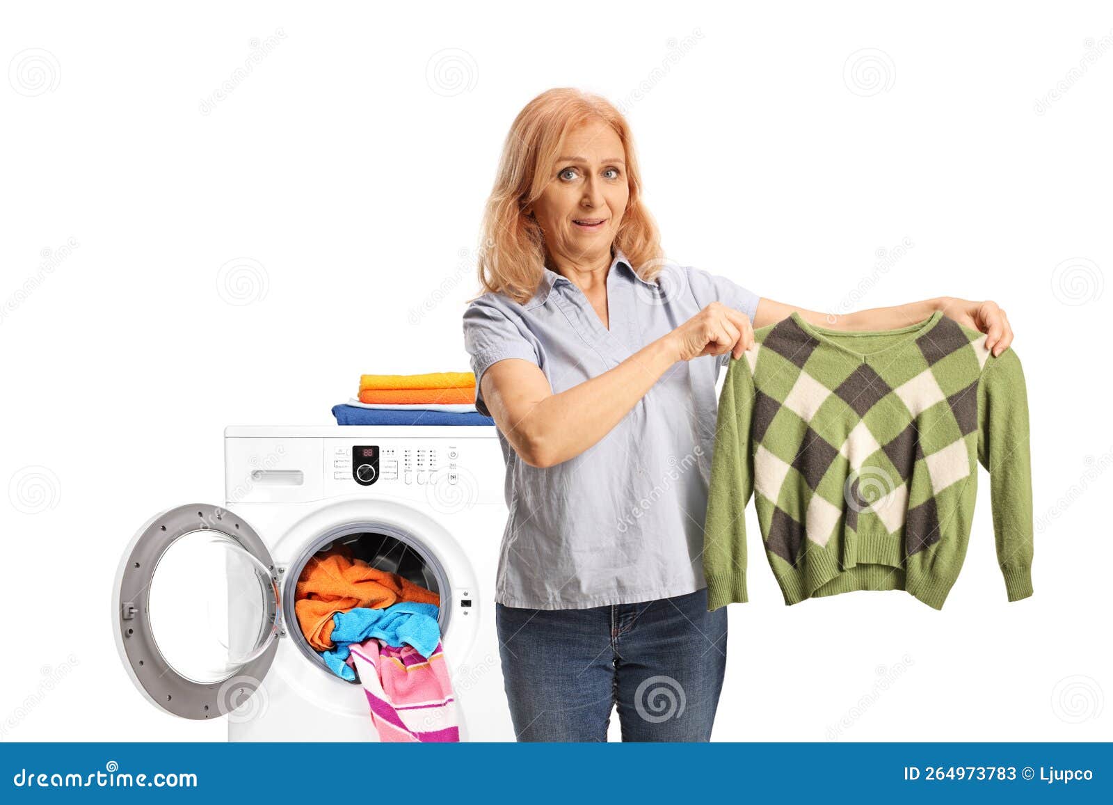 Mature Woman Taking A Green Sweather Out Of A Washing Machine Stock