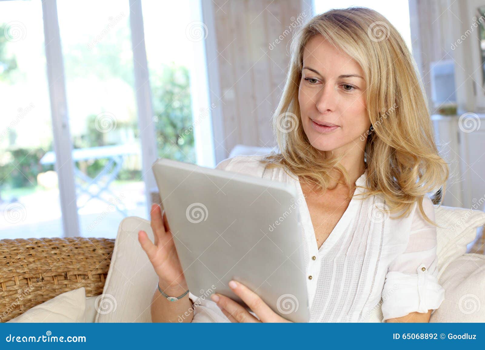 Mature woman using tablet stock photo. Image of couch - 65068892