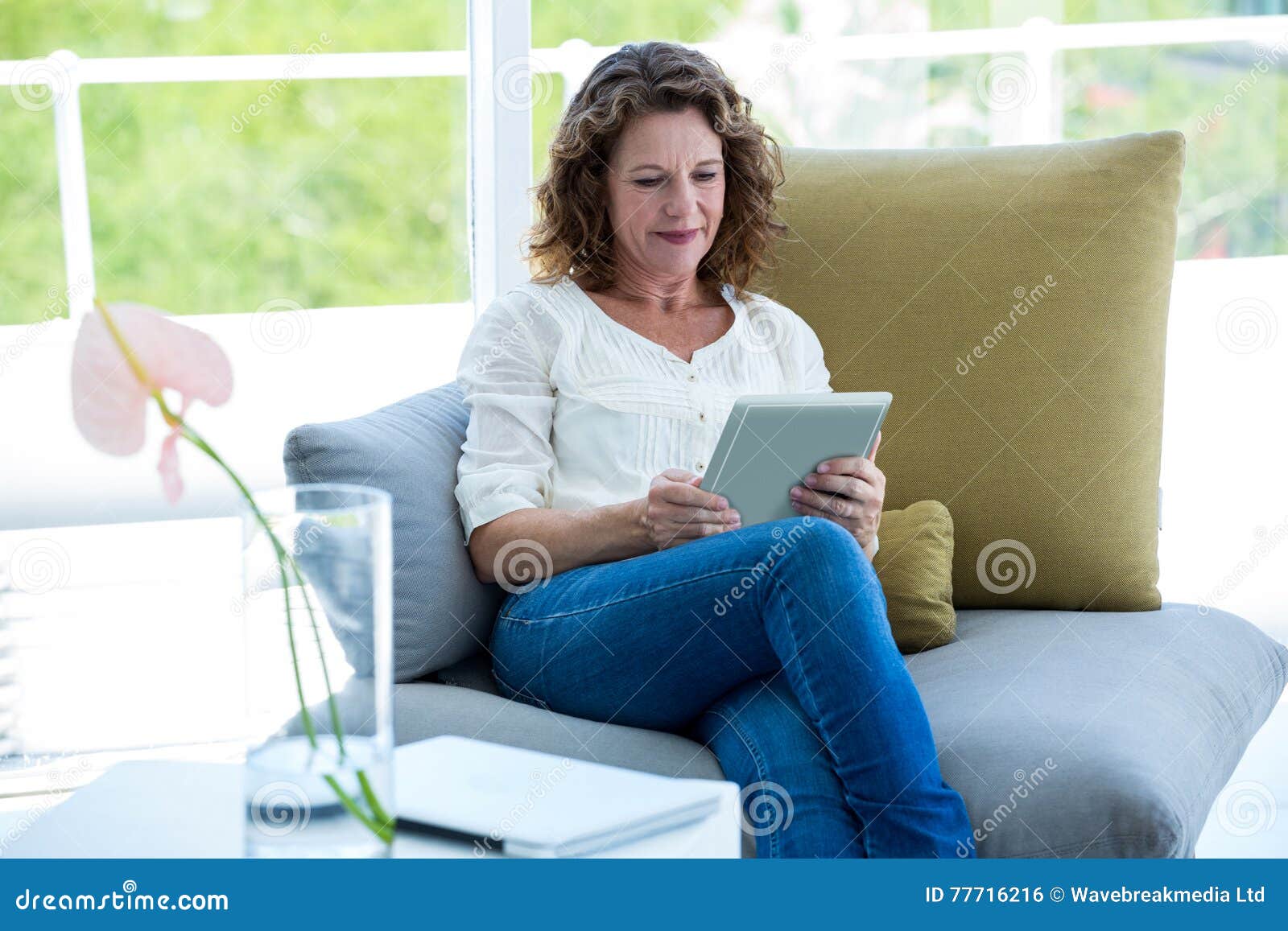 Mature woman using tablet stock photo. Image of flower - 77716216