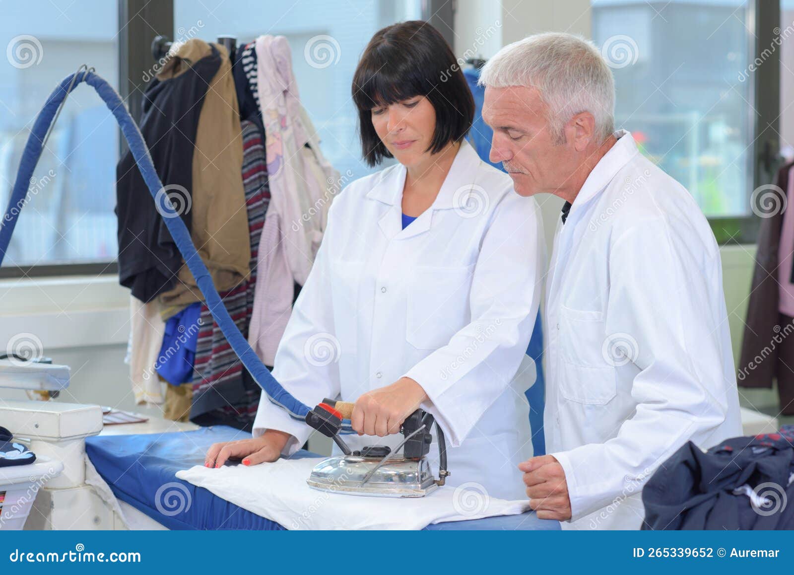 Mature Worker and Colleague Ironing Fabric Stock Photo - Image of ...