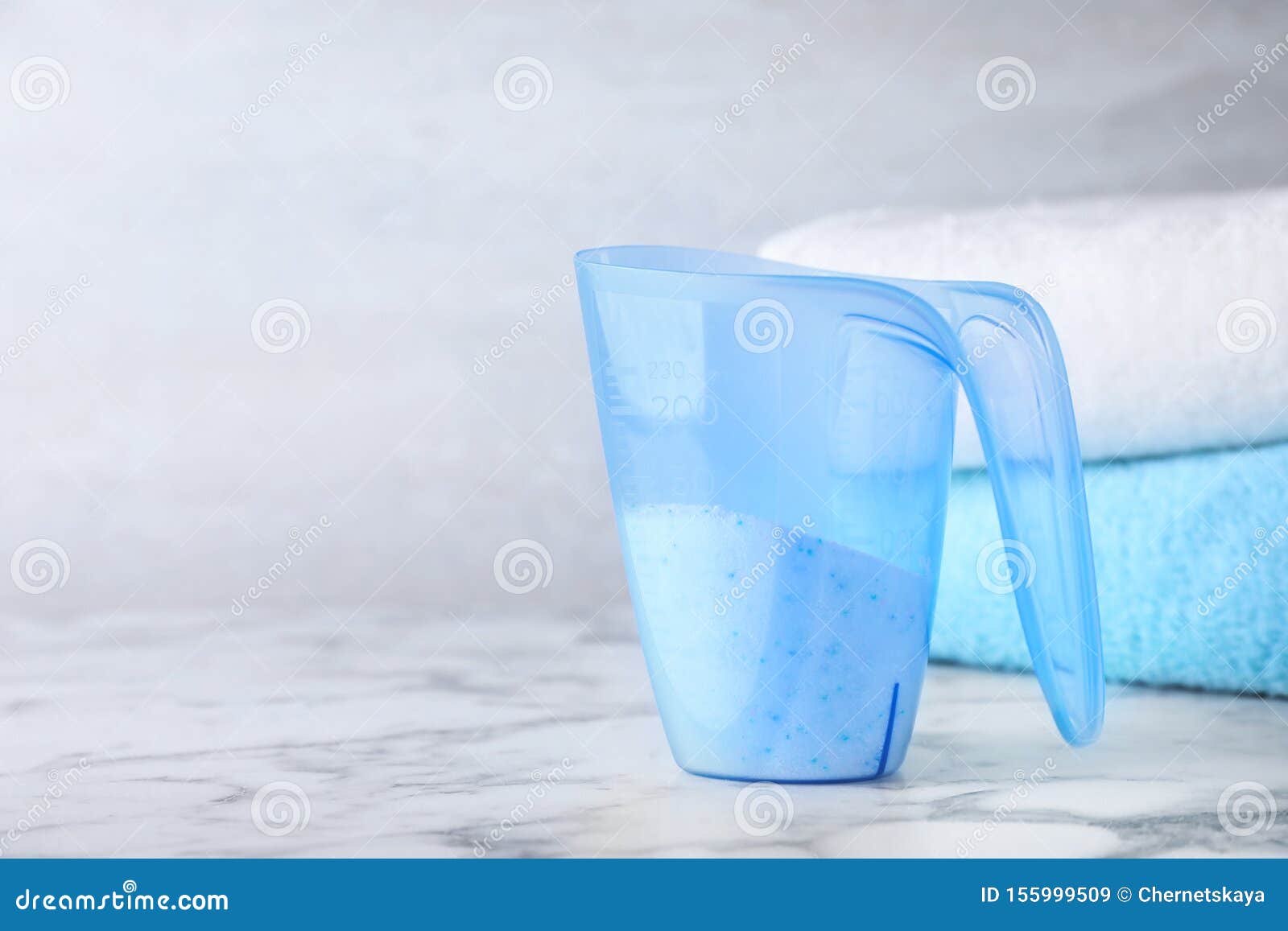 Measuring Cup of Laundry Powder and Towels on Marble Table Stock Image ...