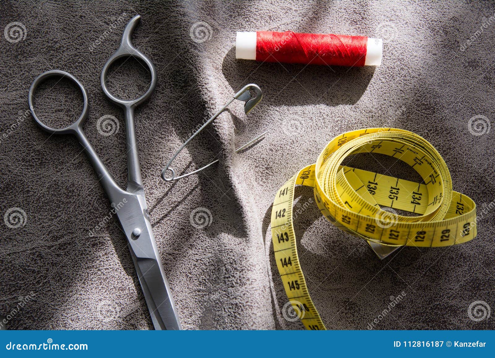 Measuring Tape, Scissors and Reel of Red Thread on Gray Fabric Stock ...