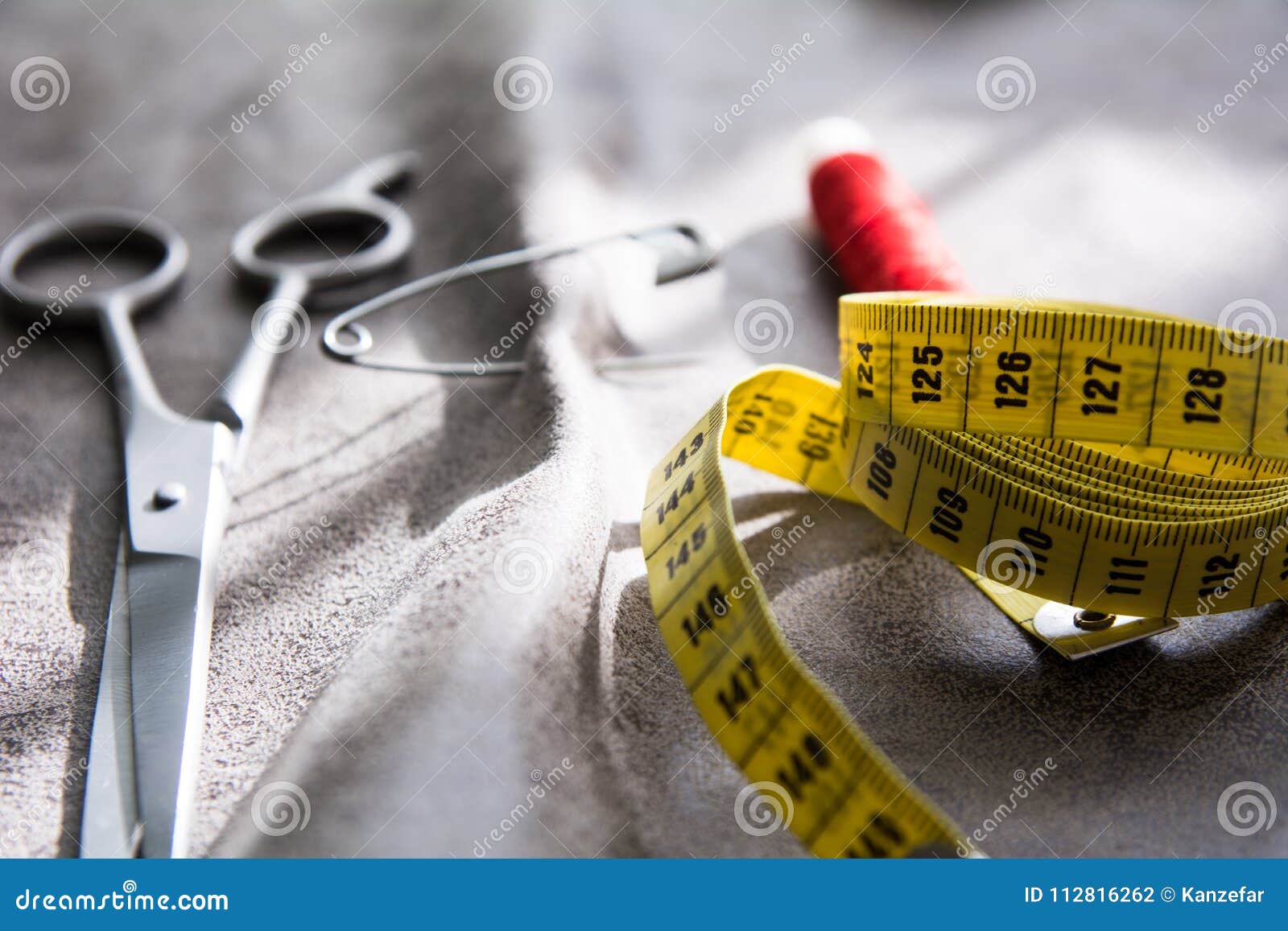 Measuring Tape, Scissors and Reel of Red Thread on Gray Fabric Stock ...