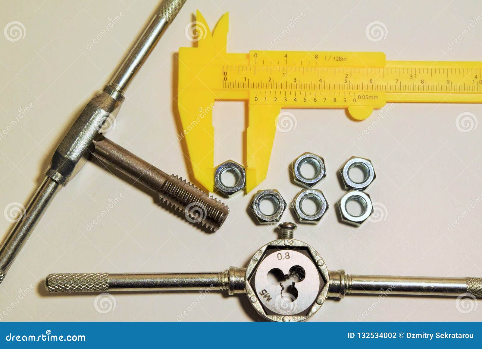 Locksmith Tool. Tap for Cutting Threads, Micrometer and Nuts on a White ...