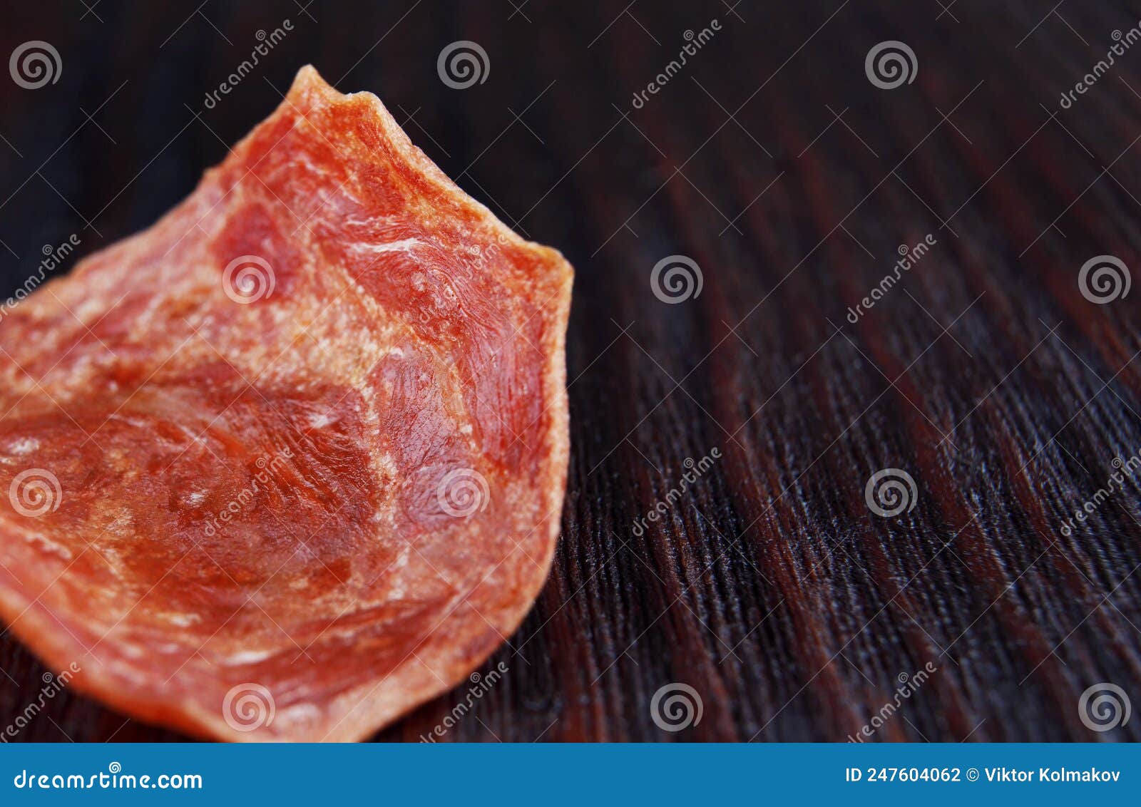 Meat Chips. a Single Piece of Dried Meat Lies on a Dark Wooden Surface ...