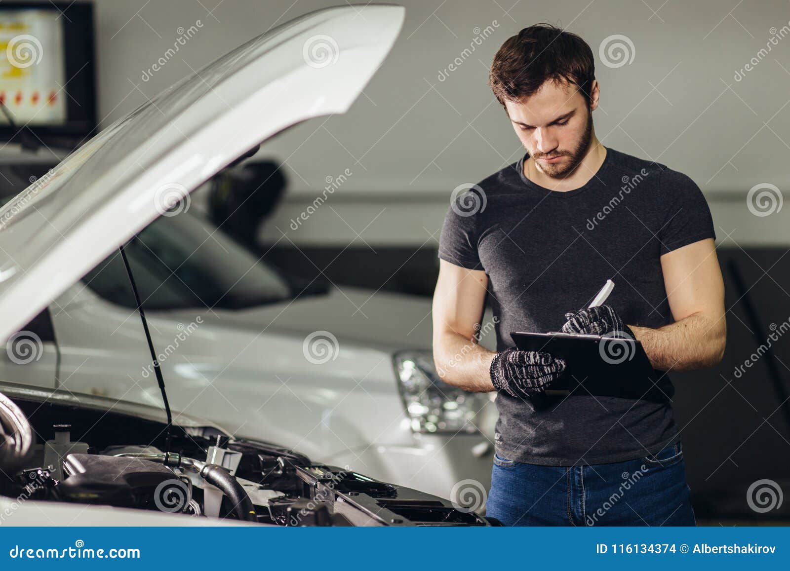 Mechachic Checking on Car Engine and Taking Notes in Clipboard Stock ...