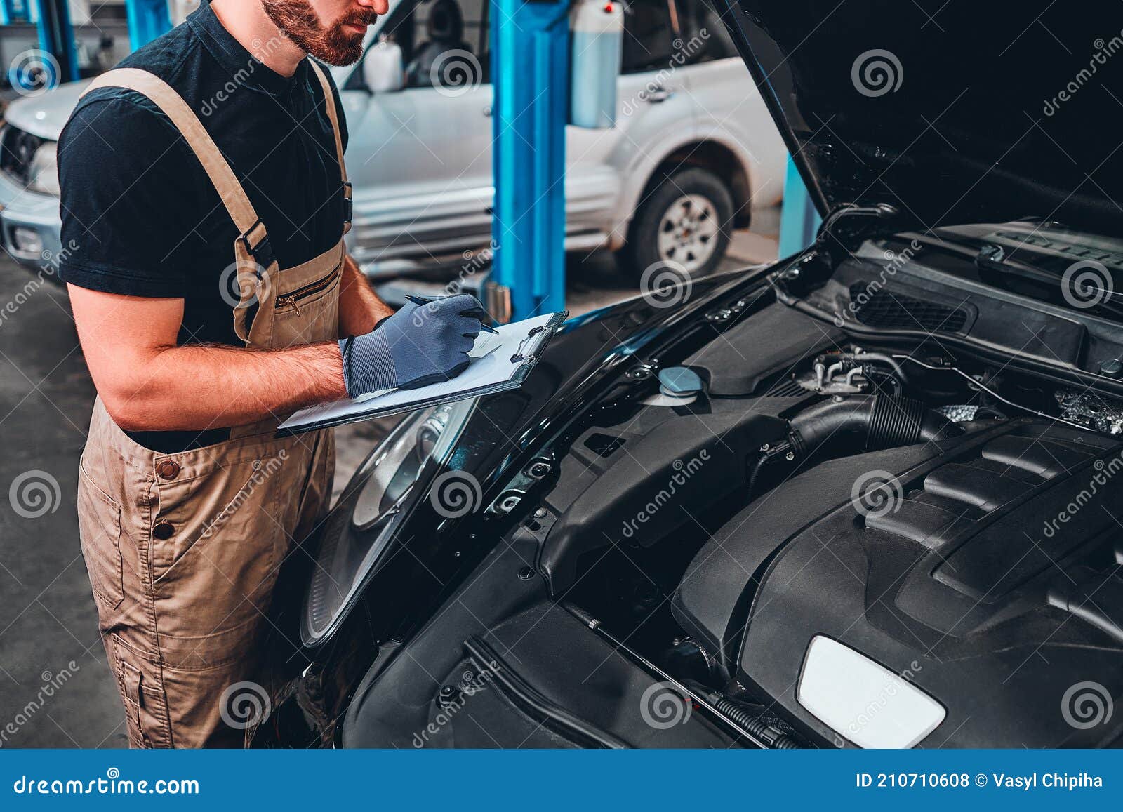 Mechachic Checking on a Car Engine and Taking Notes Stock Photo - Image ...