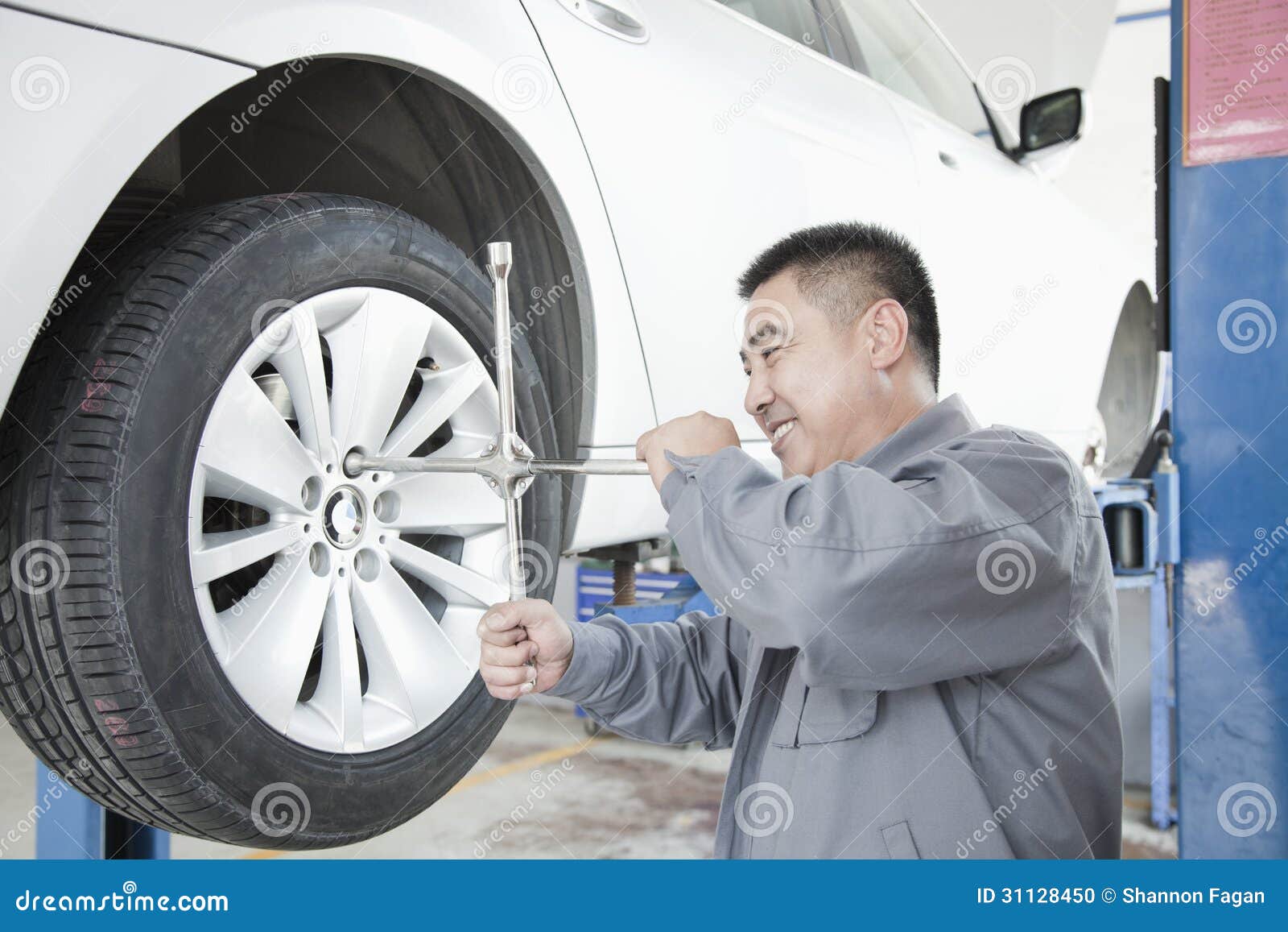 Mechanic Adjusting Tire, Smiling Stock Photo - Image of holding ...