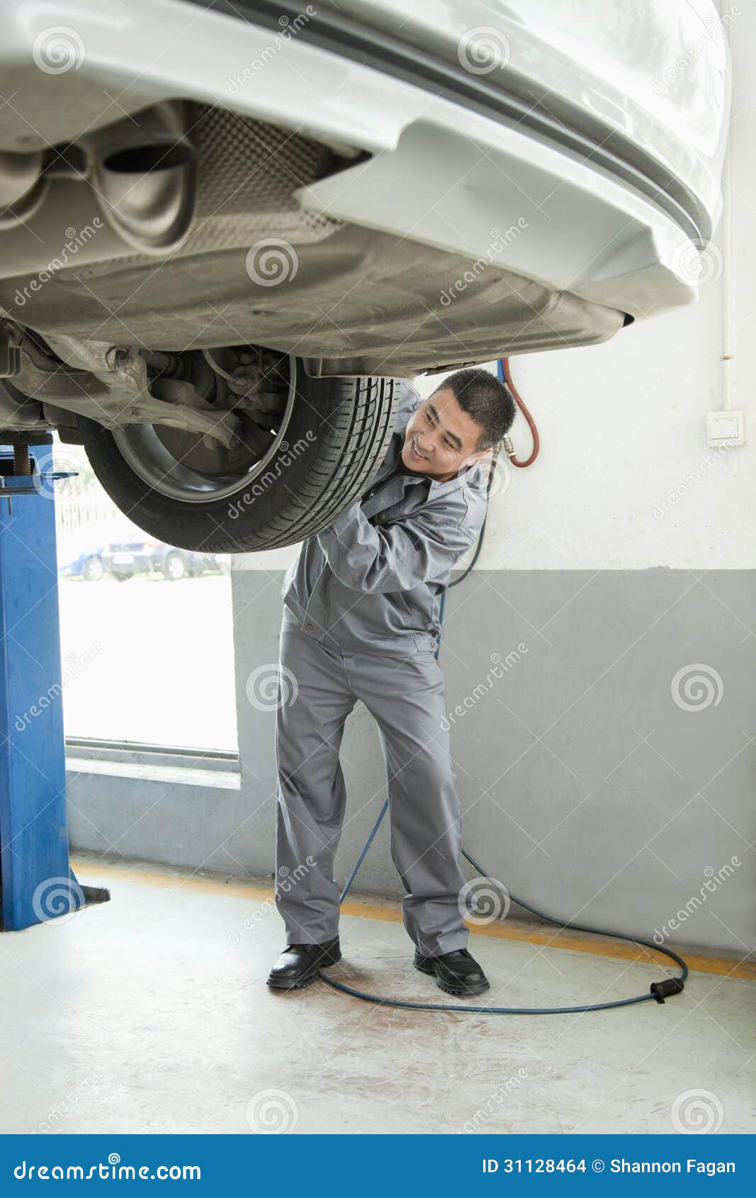 Mechanic Adjusting Tire, Smiling Stock Photo - Image of adjusting ...