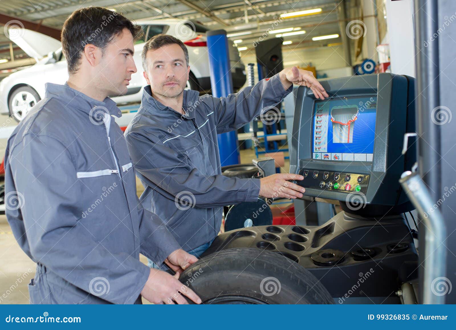 Mechanic and Apprentice Looking at Computer in Garage Stock Image ...