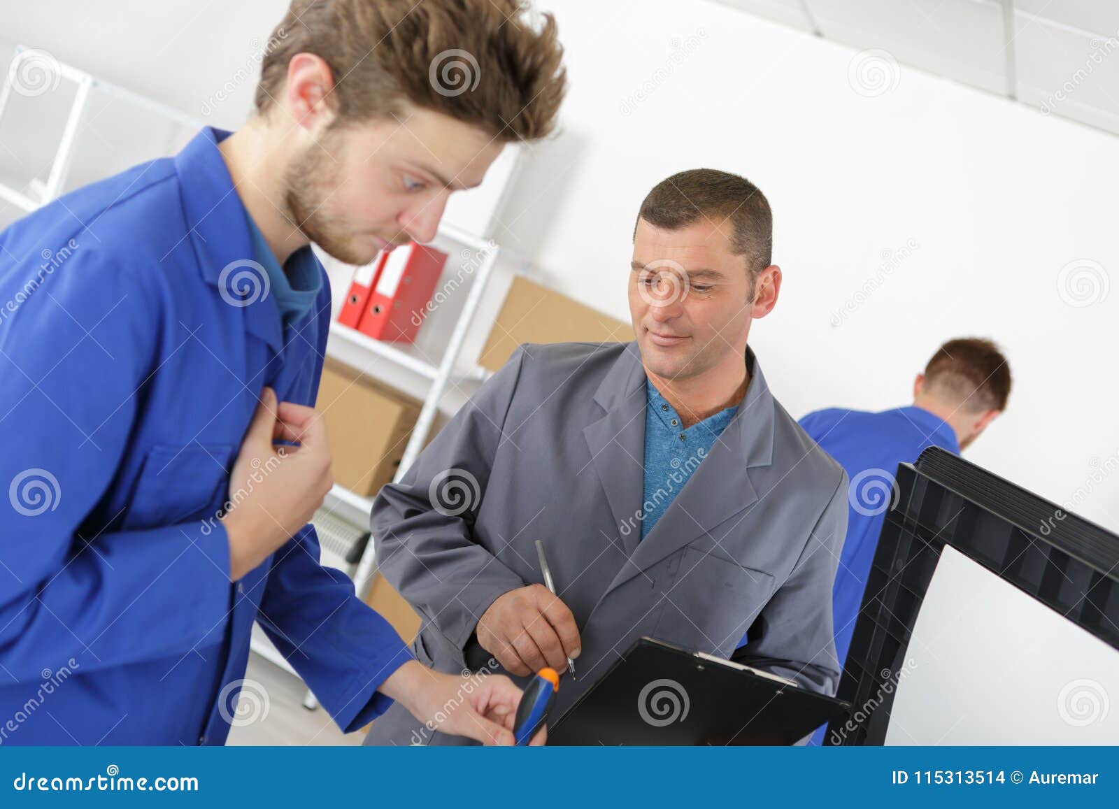 Mechanic and Apprentice Working on Car with Computer Stock Photo ...