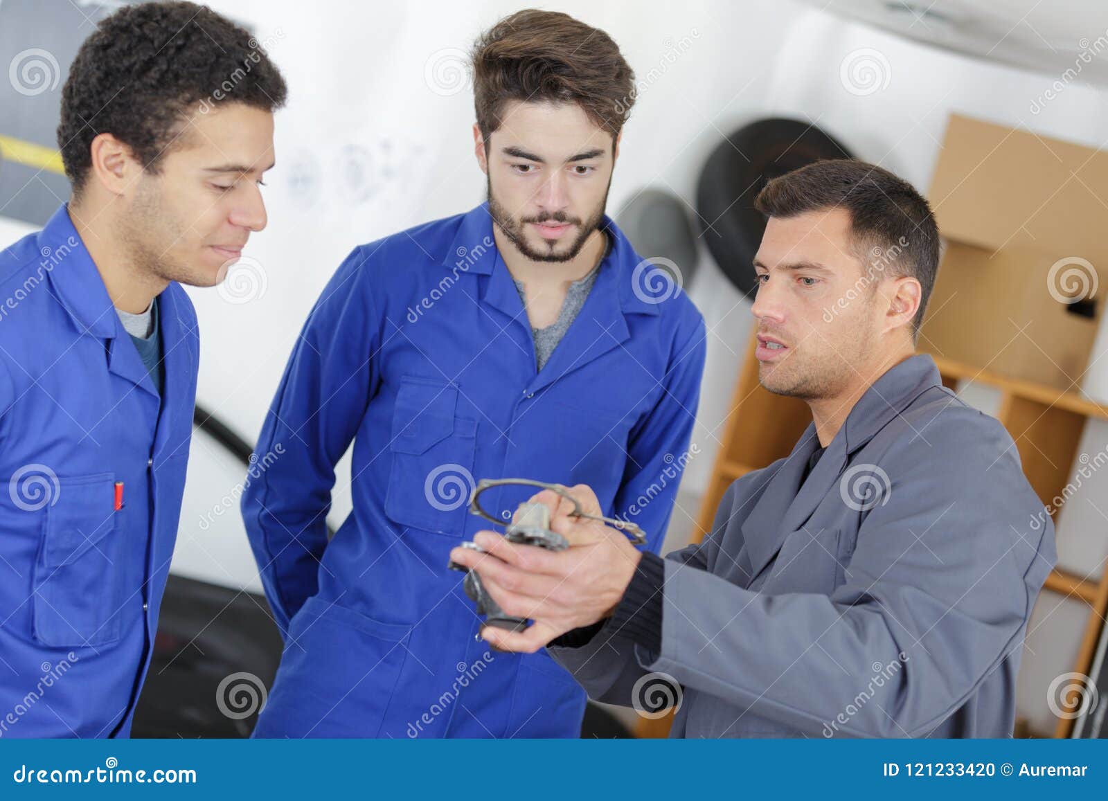 Mechanic and Apprentice Working on Car with Computer Stock Photo ...