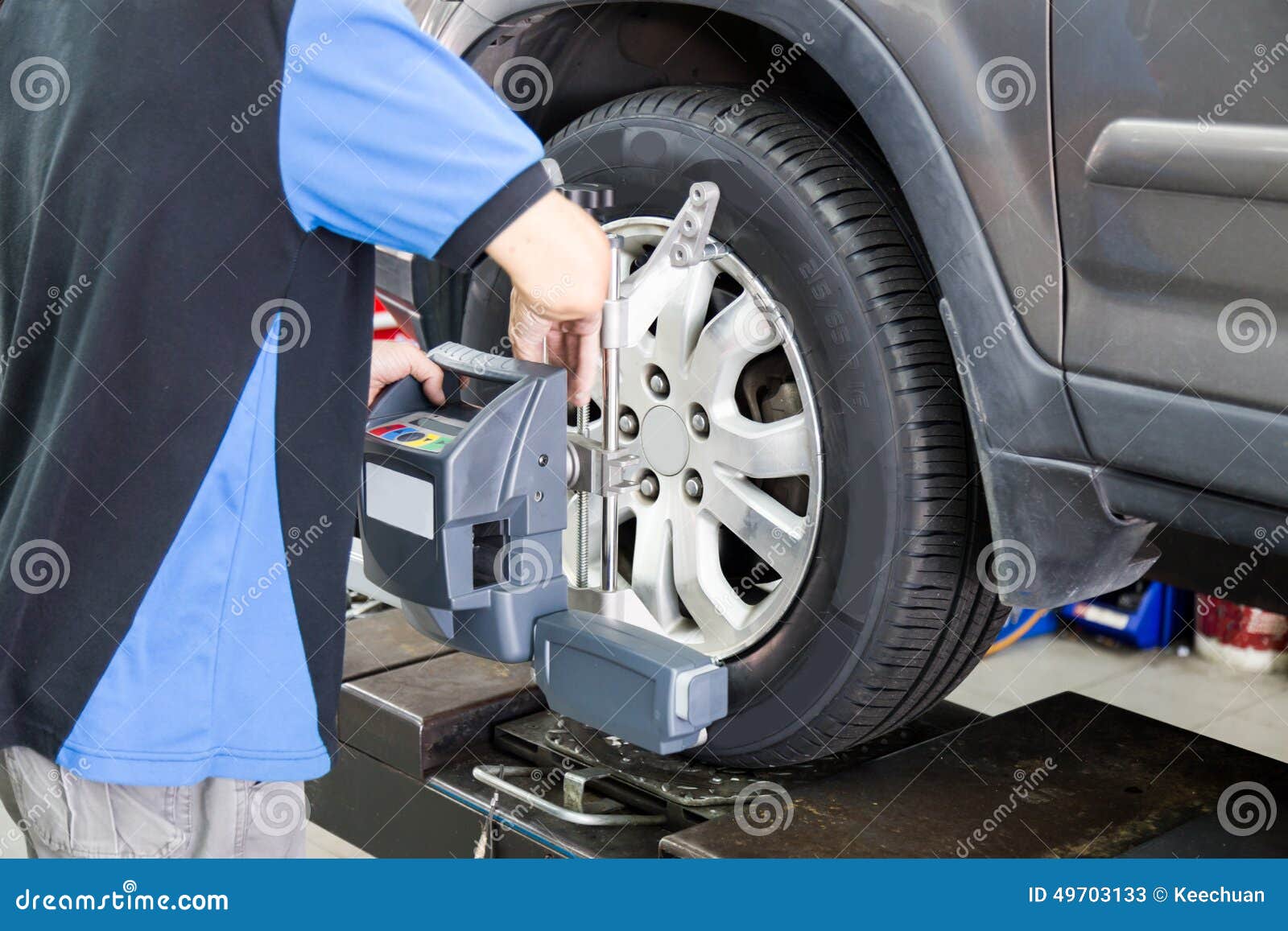 Mechanic Attaching the Wheel Alignment Device Onto the Wheel at ...