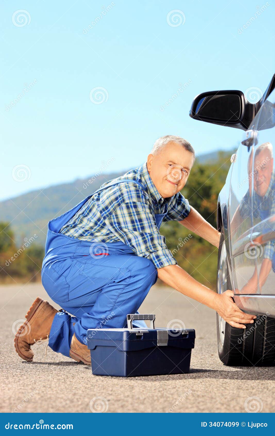 Mechanic Changing a Car Tyre on an Open Road Stock Image - Image of ...