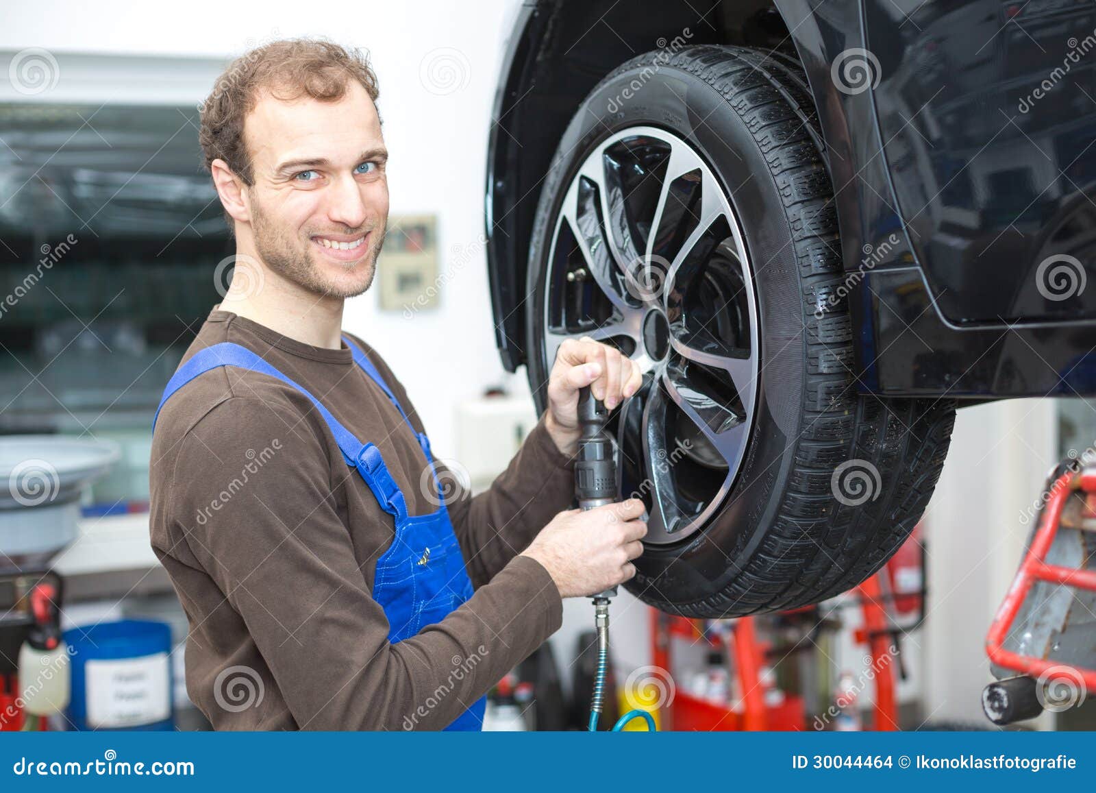 Mechanic Changing Wheels on a Car on Hydraulic Ramp Stock Photo - Image ...