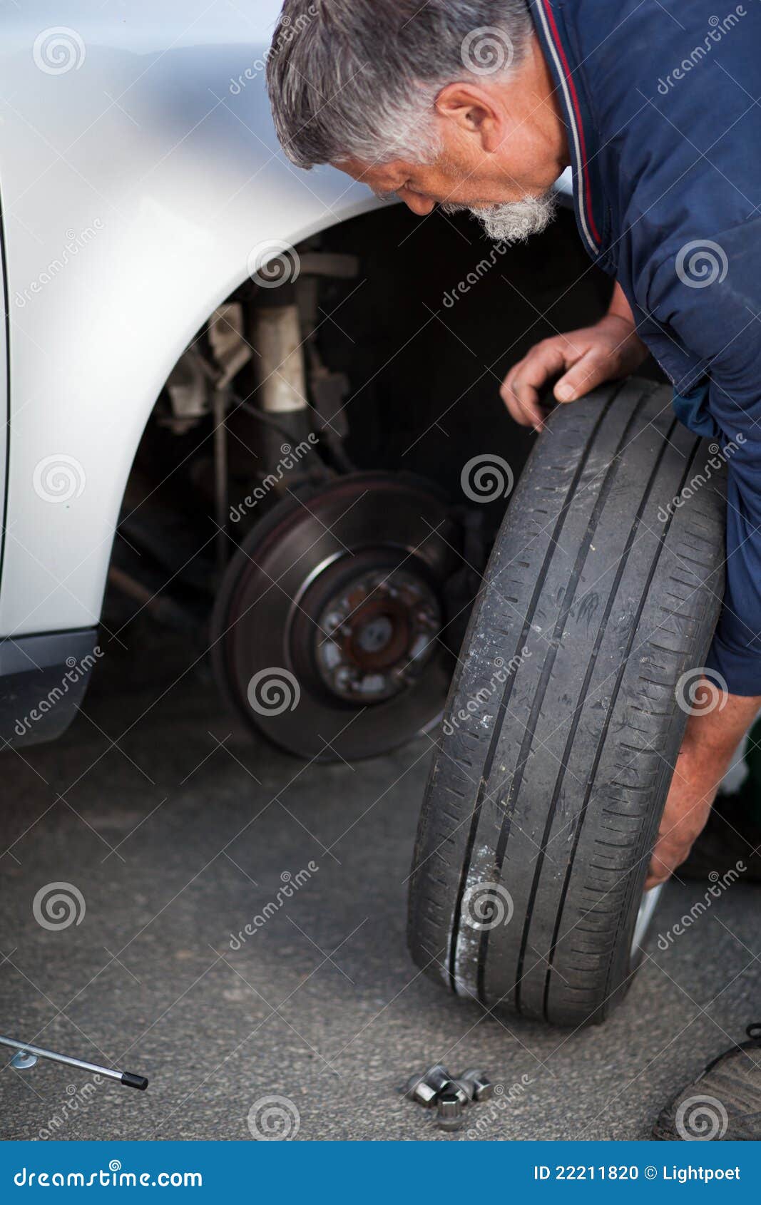 Mechanic Changing a Wheel of a Modern Car Stock Photo - Image of senior ...
