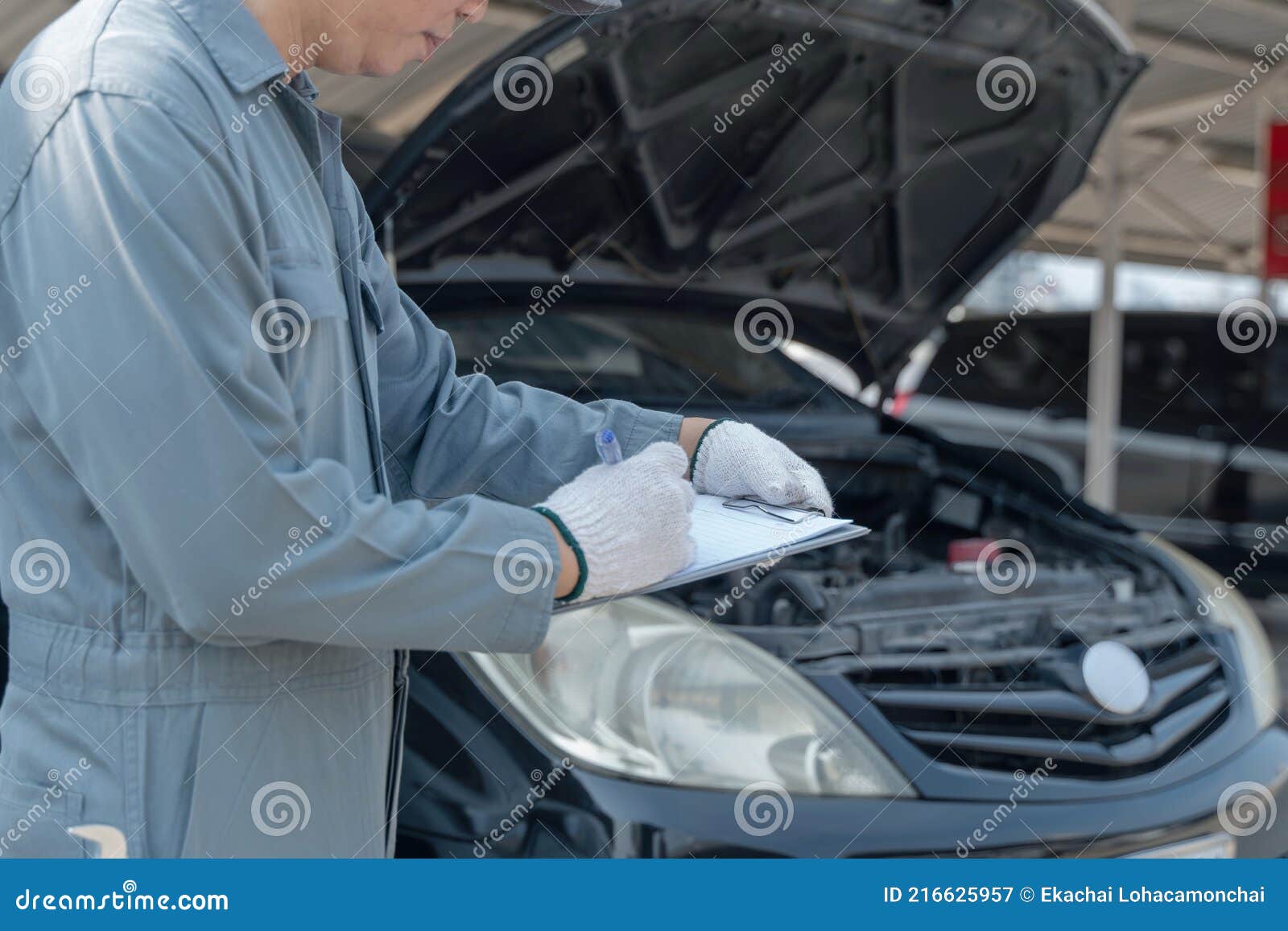 A Mechanic Checking on a Car Engine and Taking Notes Stock Image ...