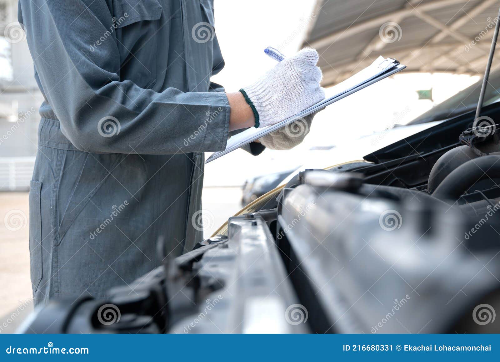 A Mechanic Checking on a Car Engine and Taking Notes Stock Image ...