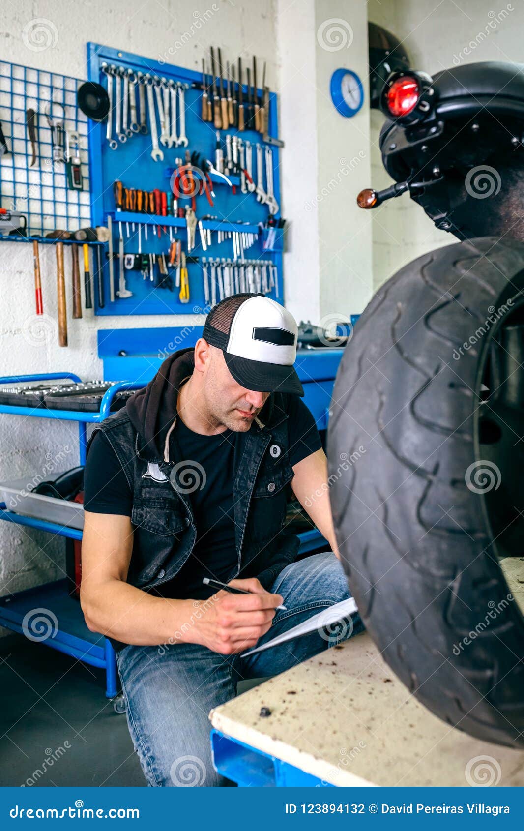 Mechanic Checking Motorcycle Stock Photo - Image of list, professional ...