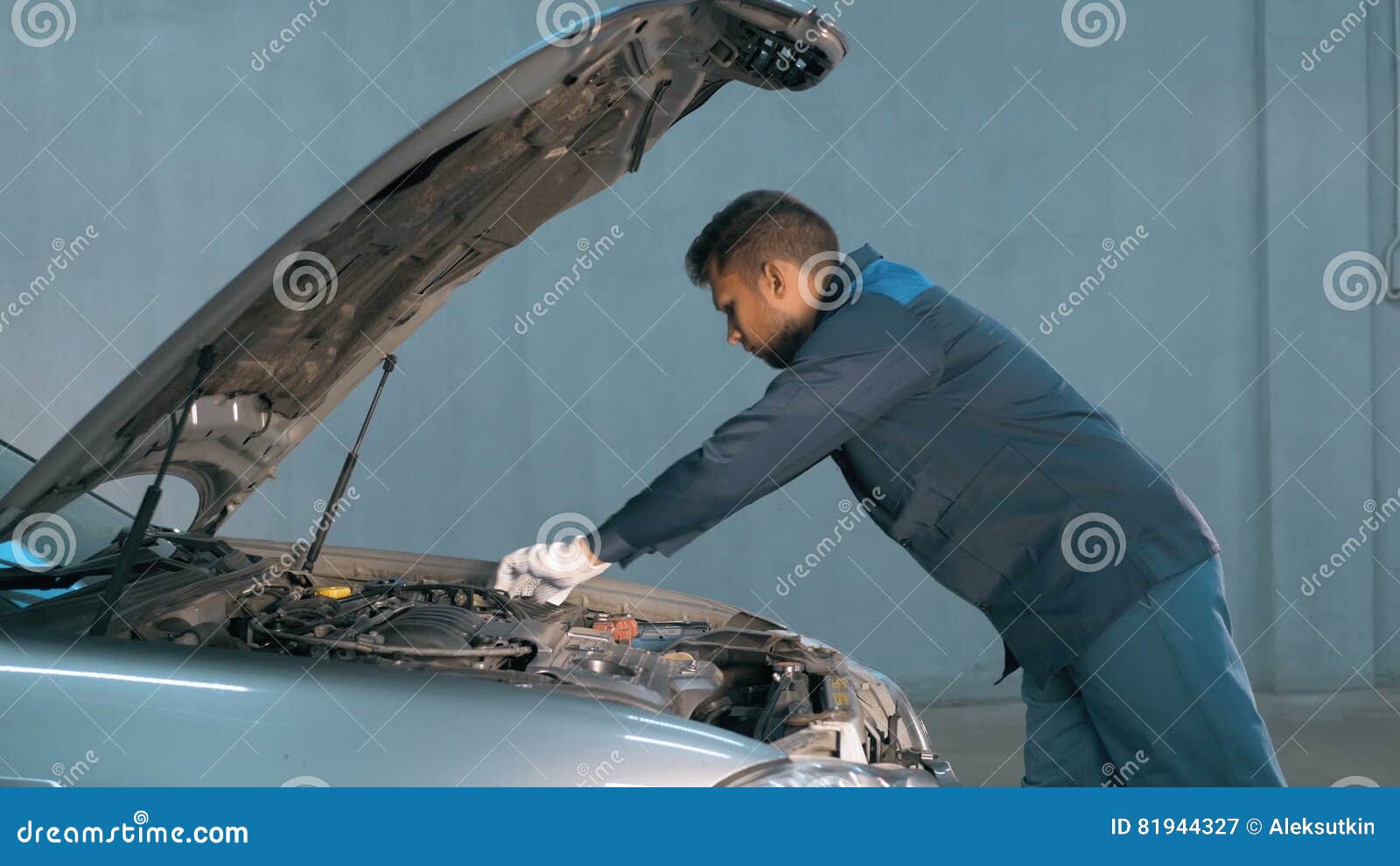 Mechanic Checking Oil Level in a Car Workshop. Man in Truck Service ...