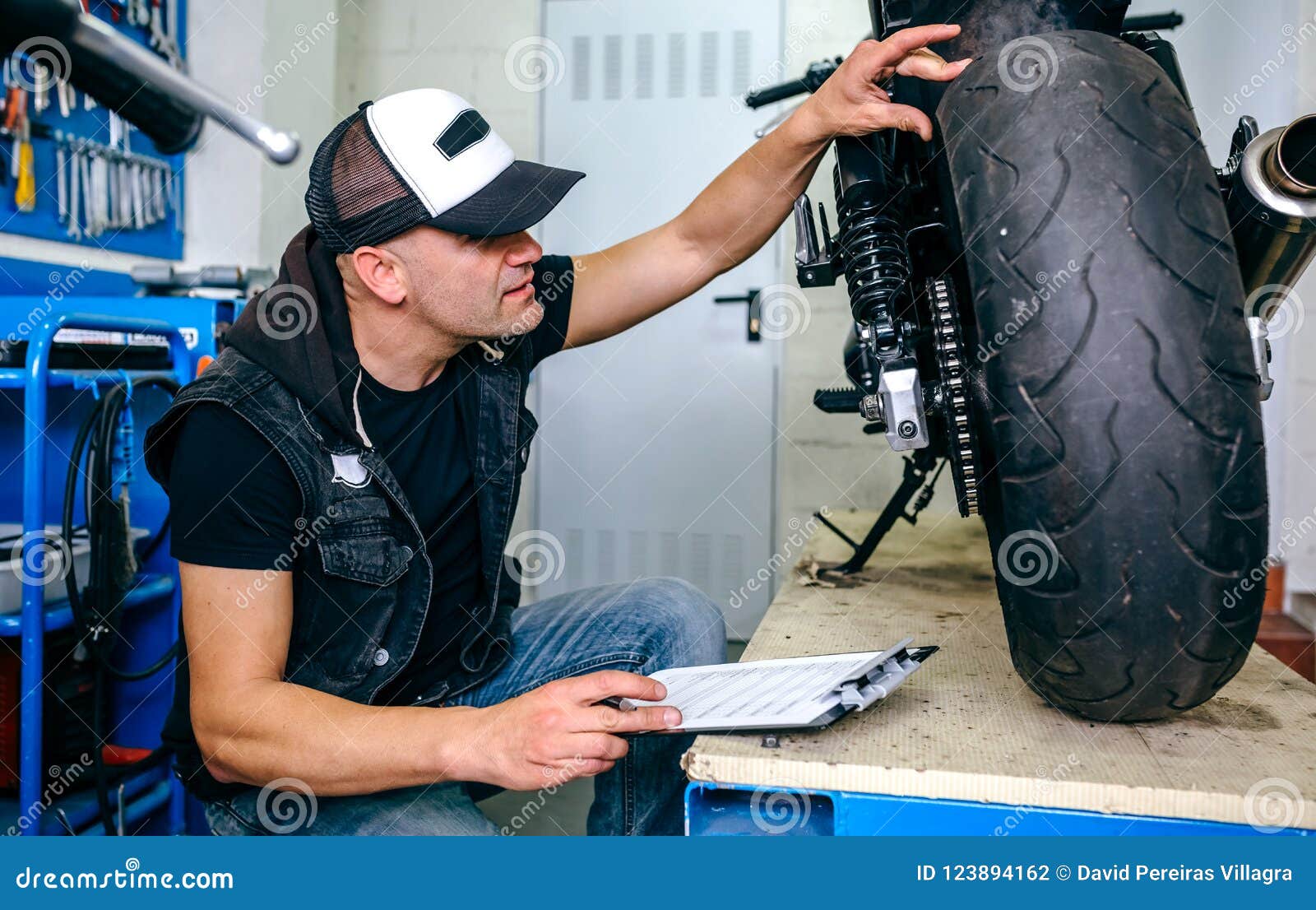 Mechanic Checking Wheel of a Customized Motorcycle Stock Photo - Image ...
