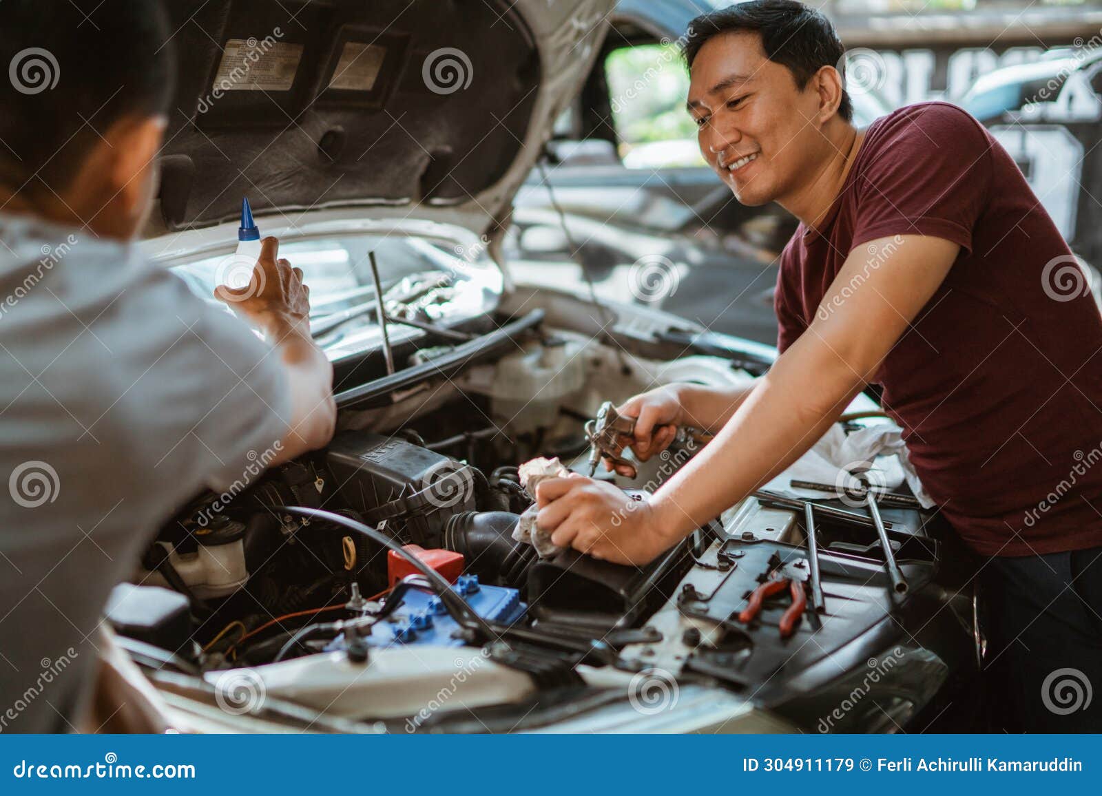 Mechanic Cleaning an Engine Using a Duster Gun with His Partner Stock ...