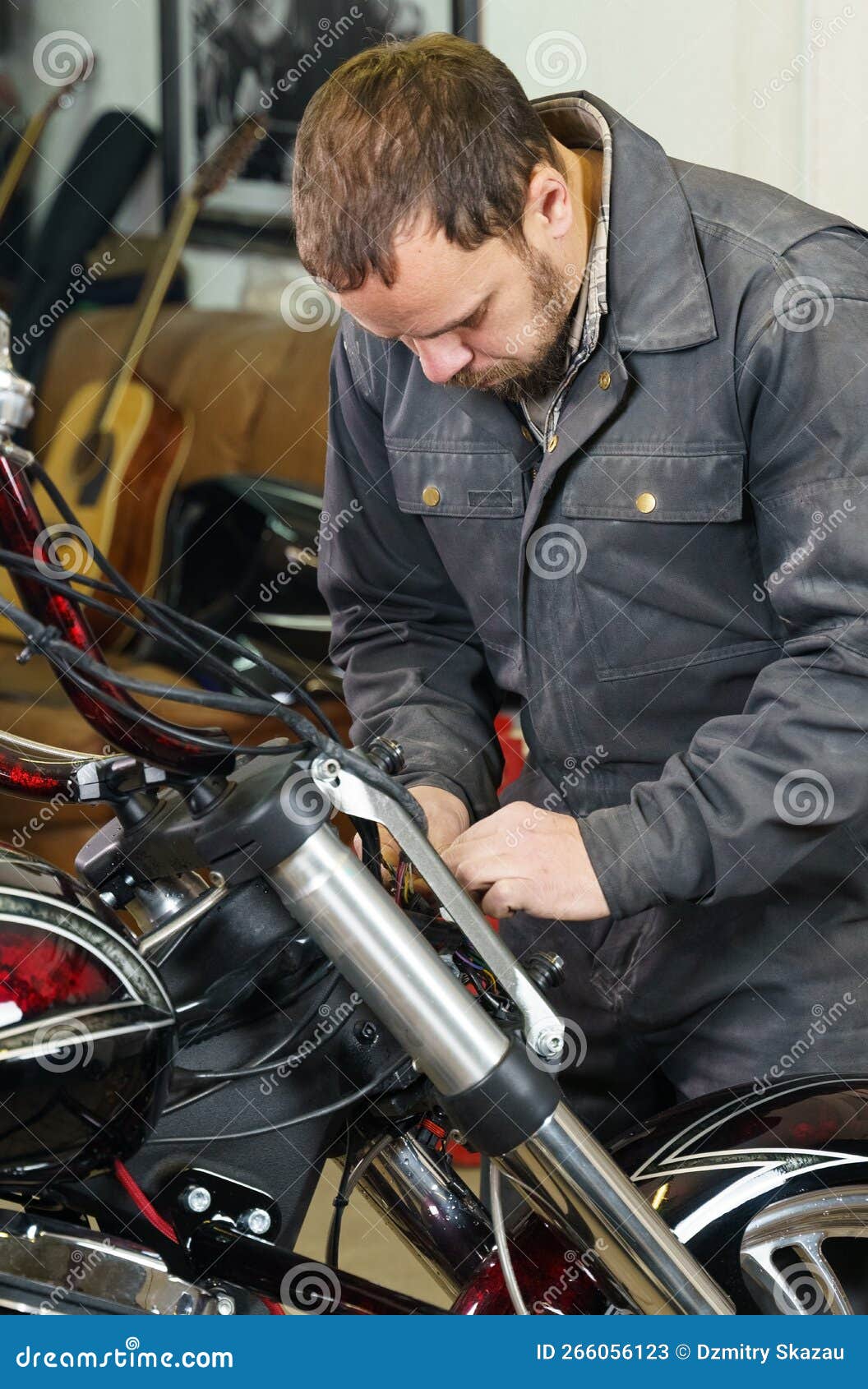 The Mechanic Connects the Electrical Cables of the Motorcycle. Vertical ...