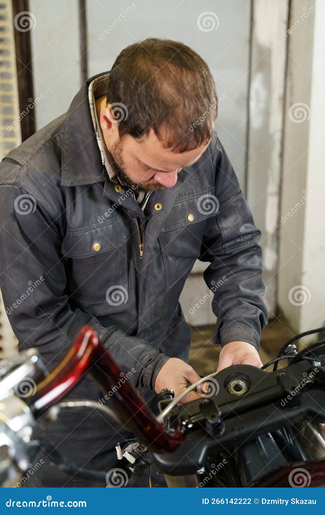 The Mechanic Connects the Electrical Cables of the Motorcycle. Vertical ...