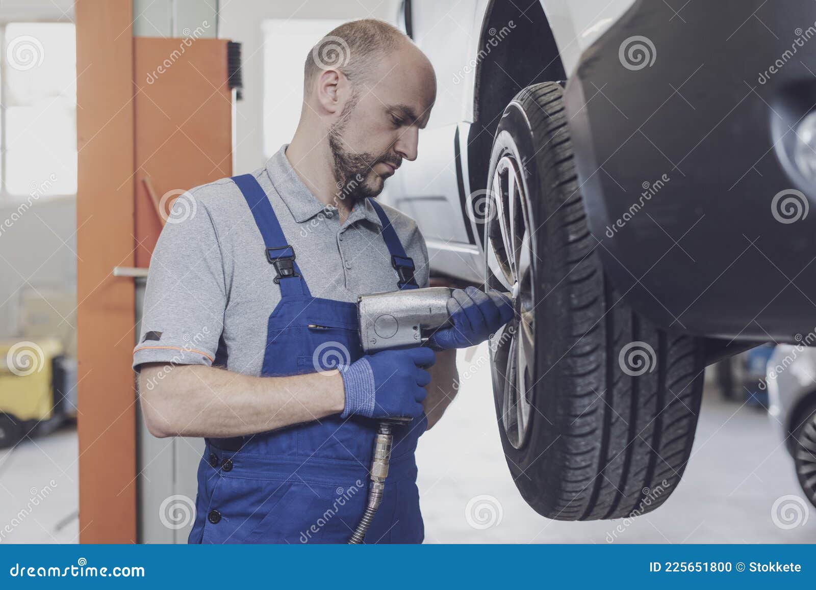 Mechanic Doing a Wheel Replacement Using a Pneumatic Wrench Stock Photo ...
