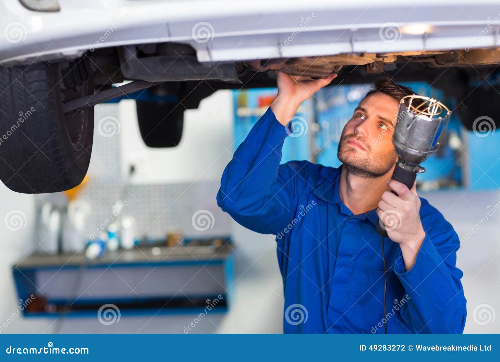 Mechanic Examining Under the Car with Torch Stock Photo - Image of ...