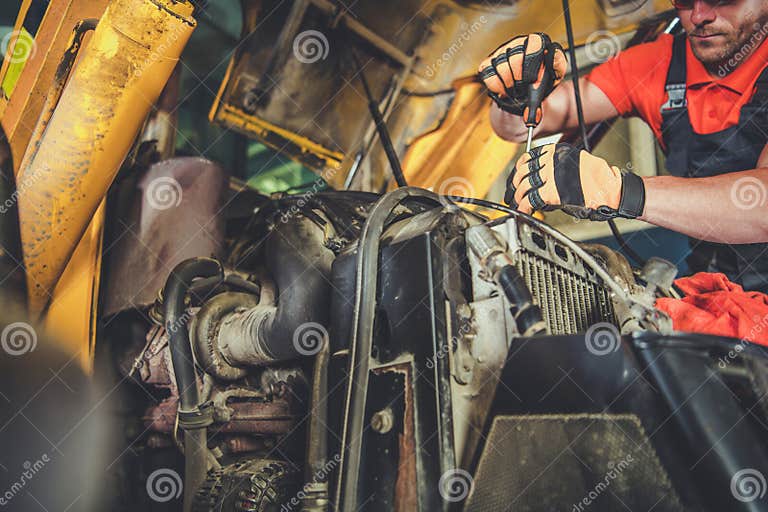 Mechanic Repairing Heavy Machinery Engine in Workshop during Daylight ...