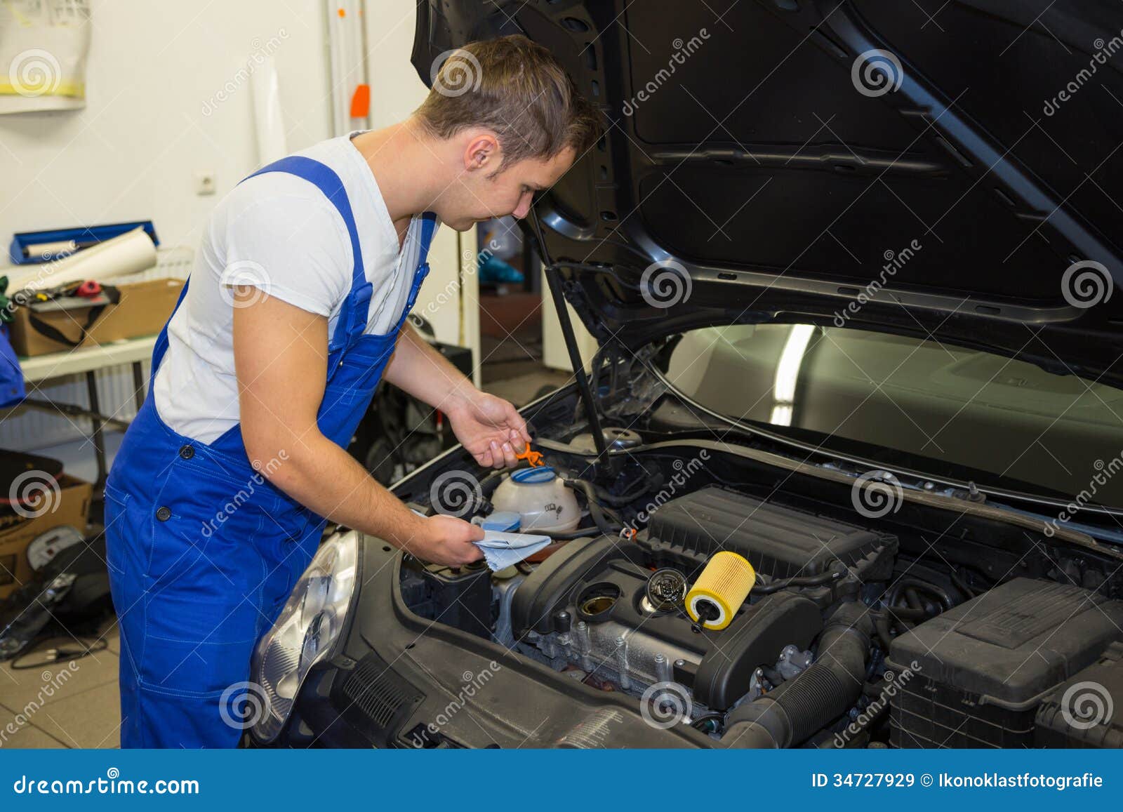 Mechanic in Garage Checking Motor Oil Level at a Car Stock Image ...