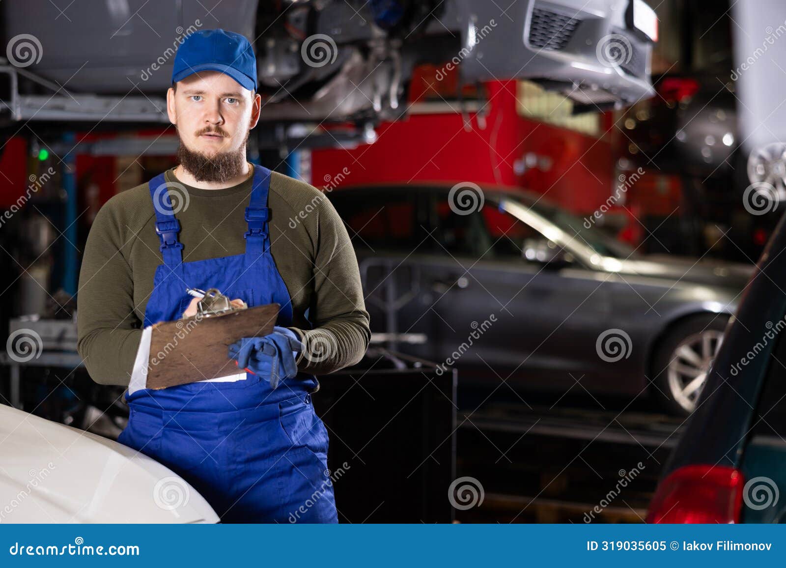 Mechanic Guy Posing with Documents in Car Service Station Stock Image ...