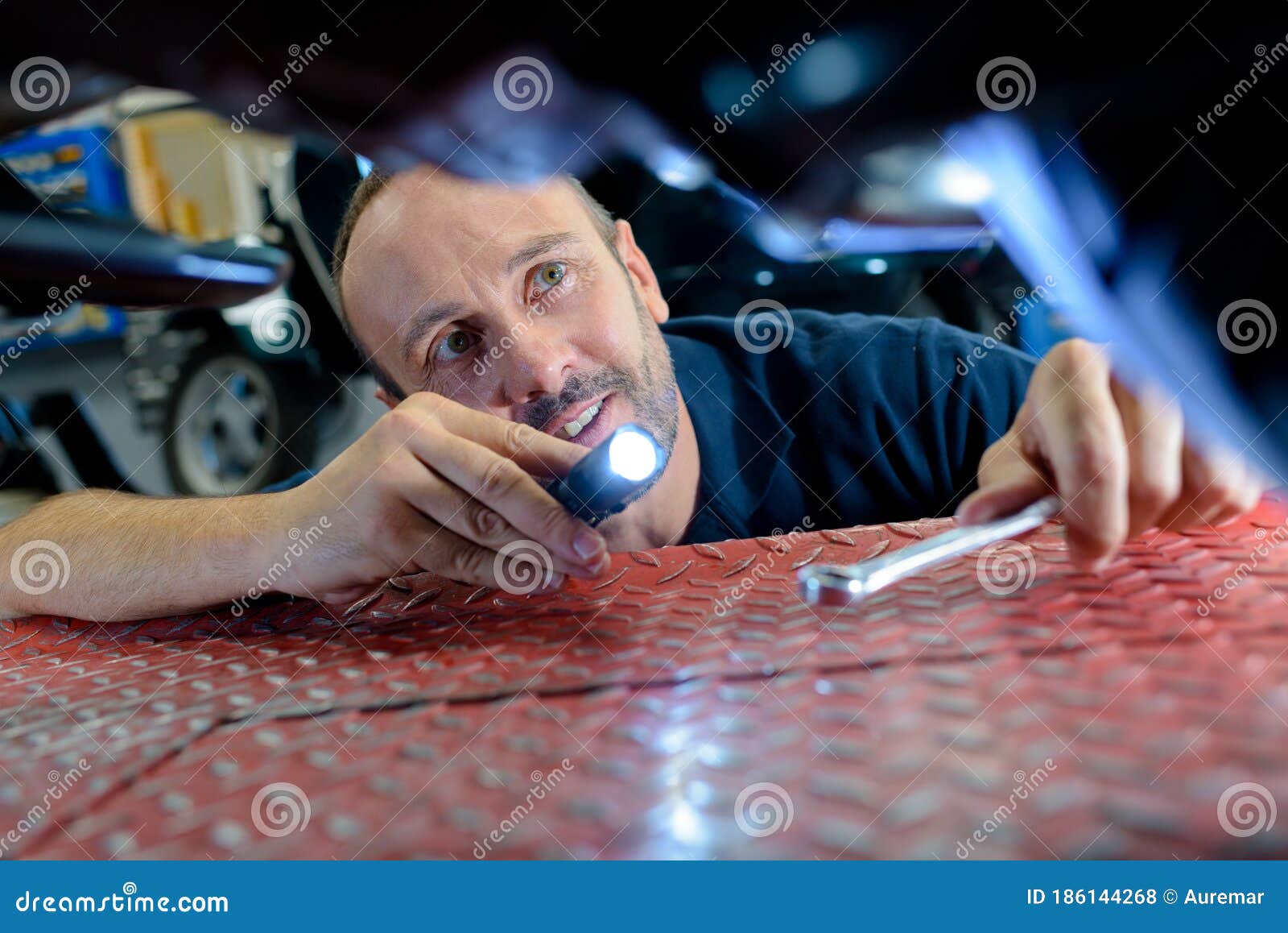 Mechanic holding a torch stock photo. Image of uniform - 186144268