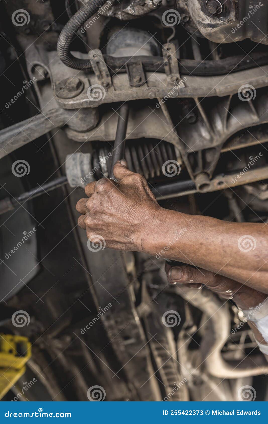 A Mechanic Inspects the Engine Support Underneath a Car, Tightening it ...