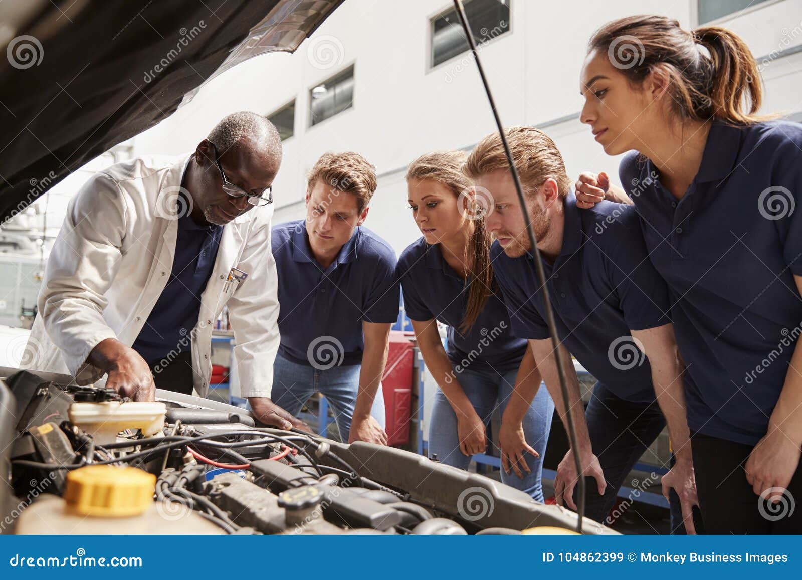 Mechanic Instructing Trainees Around a Car Engine, Low Angle Stock ...