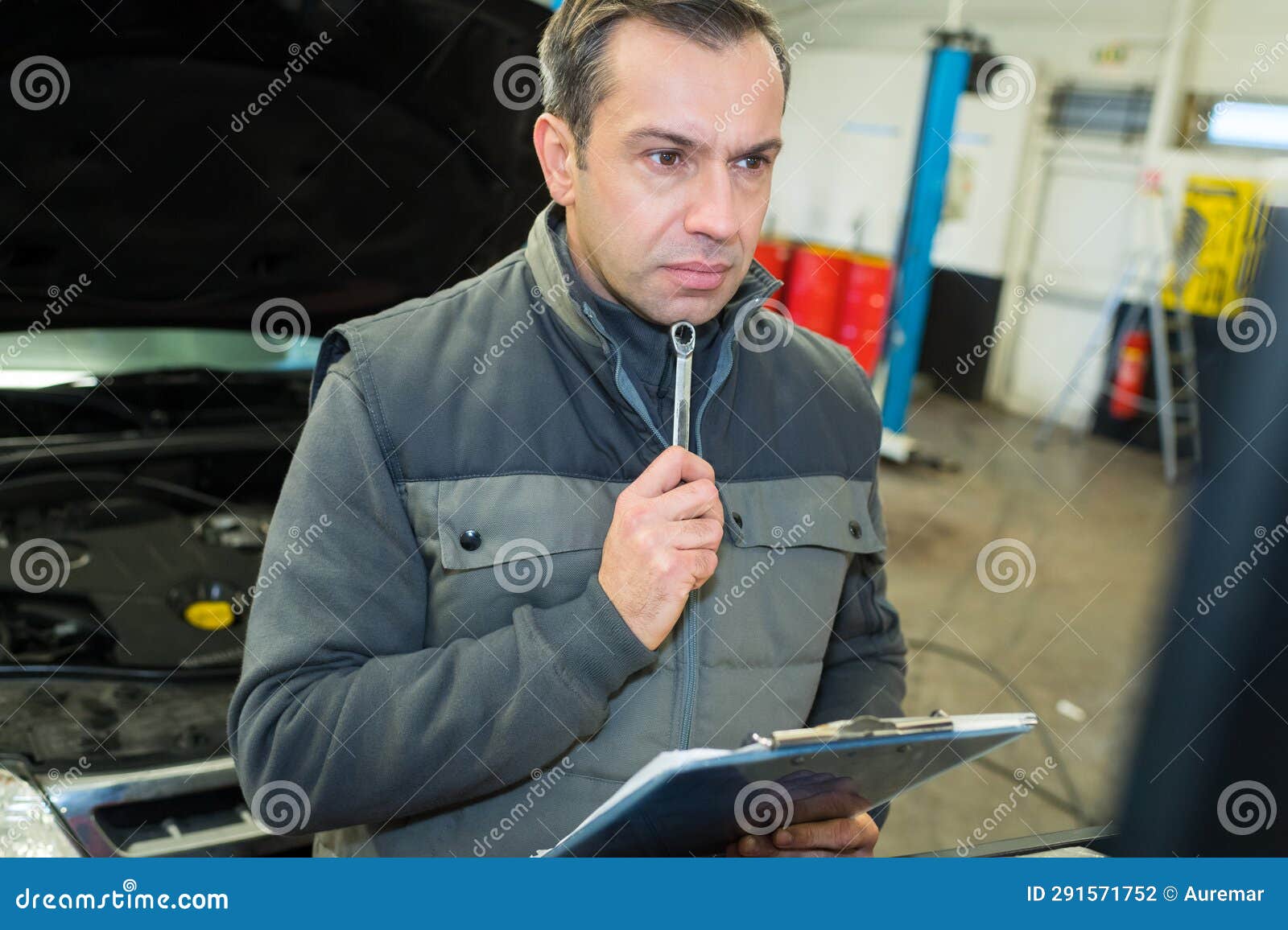 Mechanic Looking at Screen in Garage Stock Photo - Image of design ...
