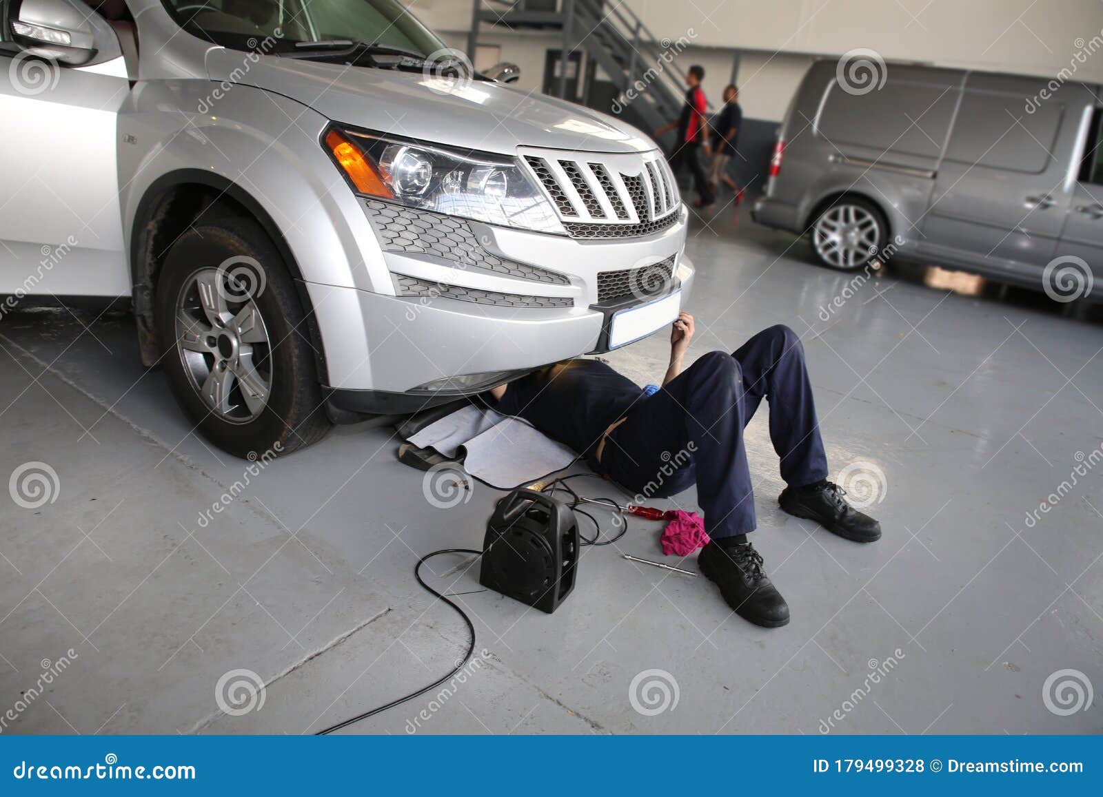 Mechanic Working Under a Car, on Its Motor. Stock Photo - Image of ...