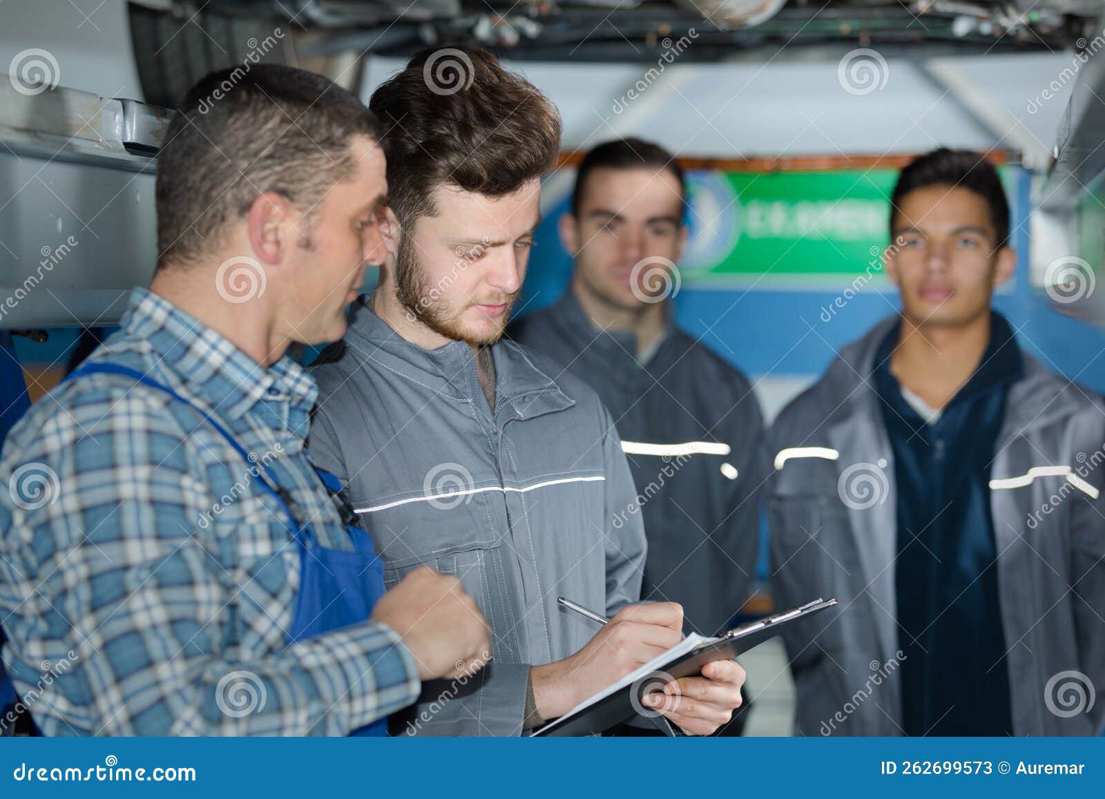 Mechanic and Male Trainee Working Underneath Car Together Stock Image ...